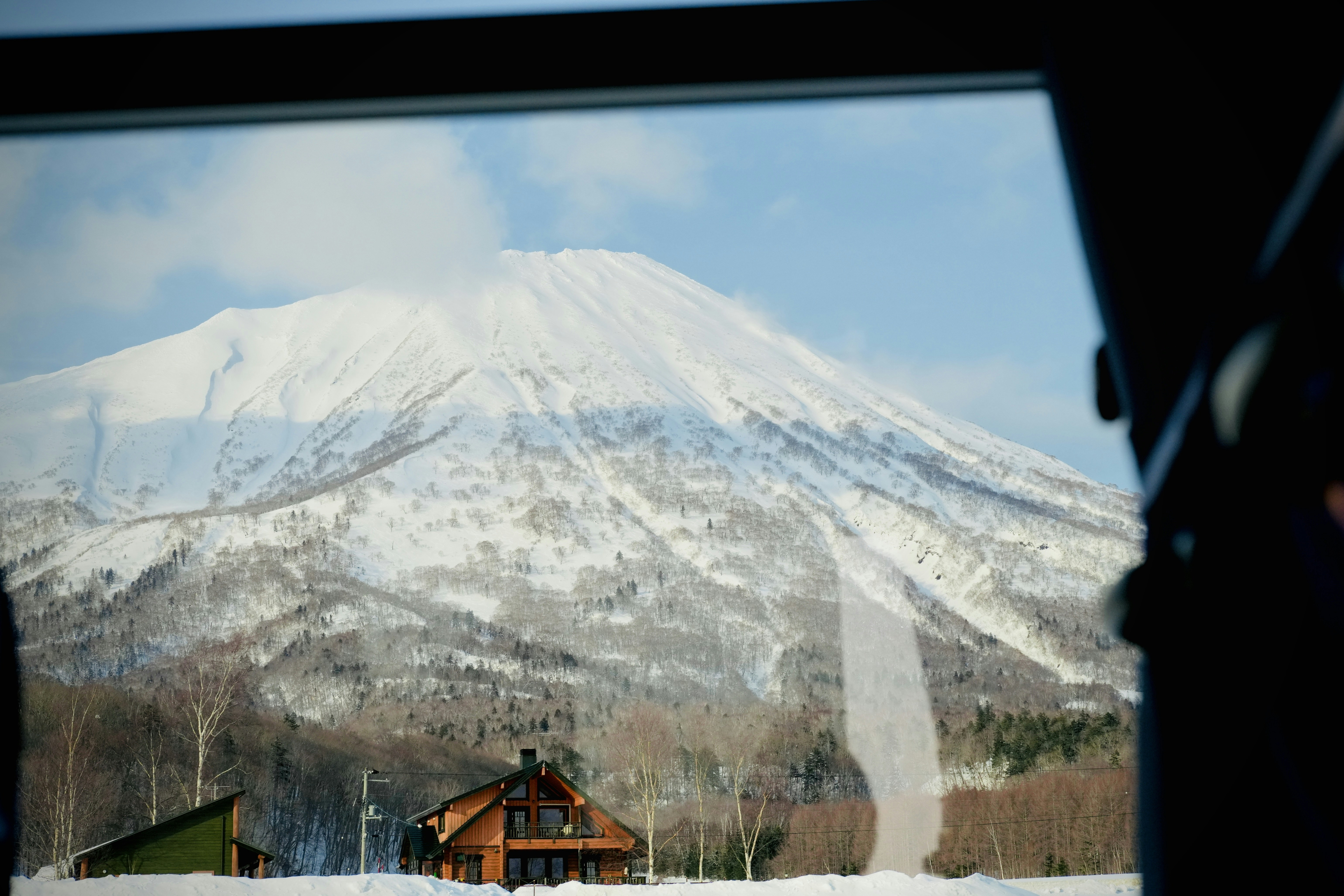 Snowy mountain view through a window with a cabin. photo – Free Man Image on Unsplash