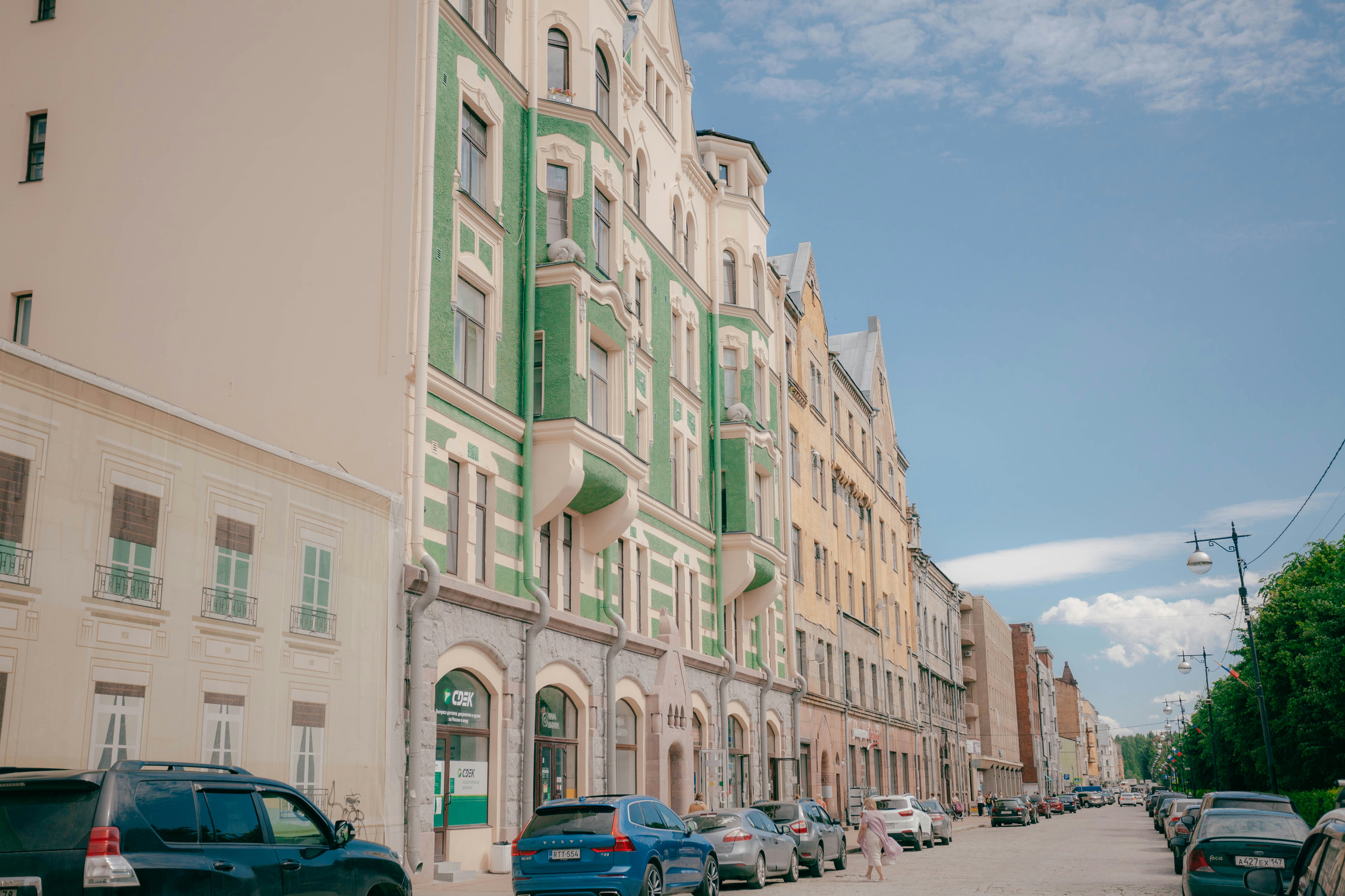 Colorful historic buildings line a sunny street under a clear blue sky.