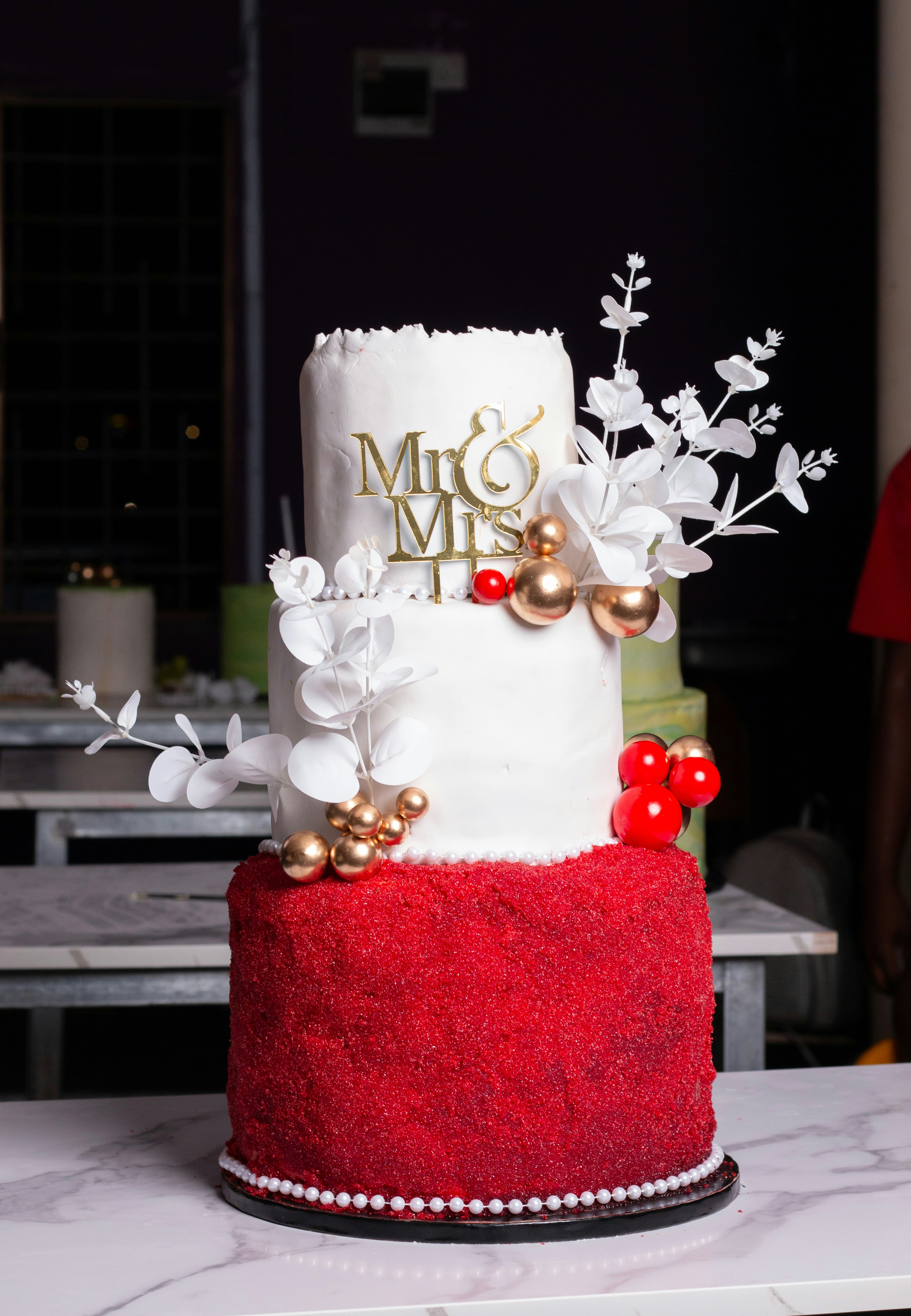 Mr & Mrs Crest: A Two-Tier Wedding Cake with Velvet Red Base and White Florals