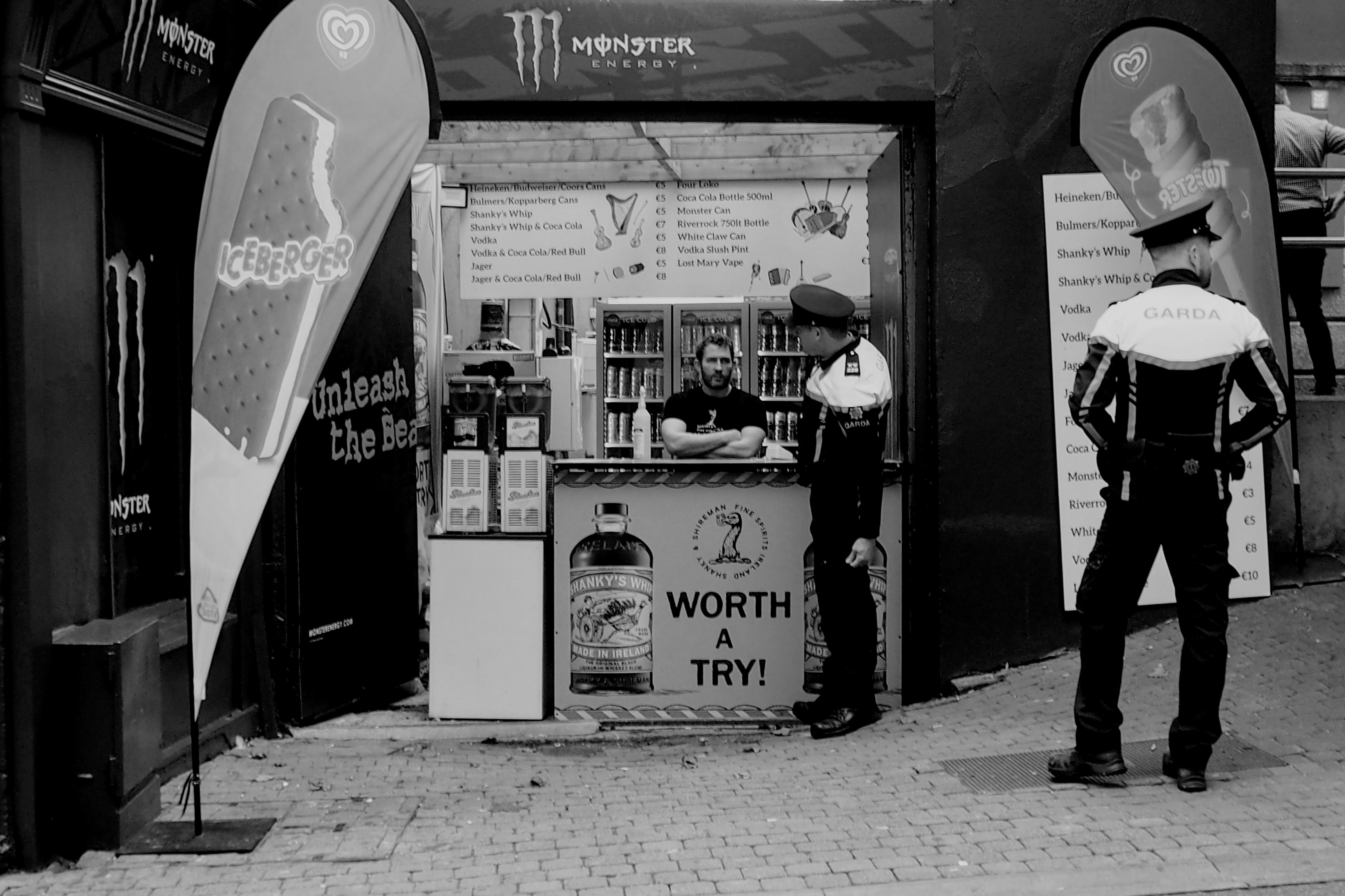 Quiet Transaction at a Kiosk: A Black-and-White Street Moment