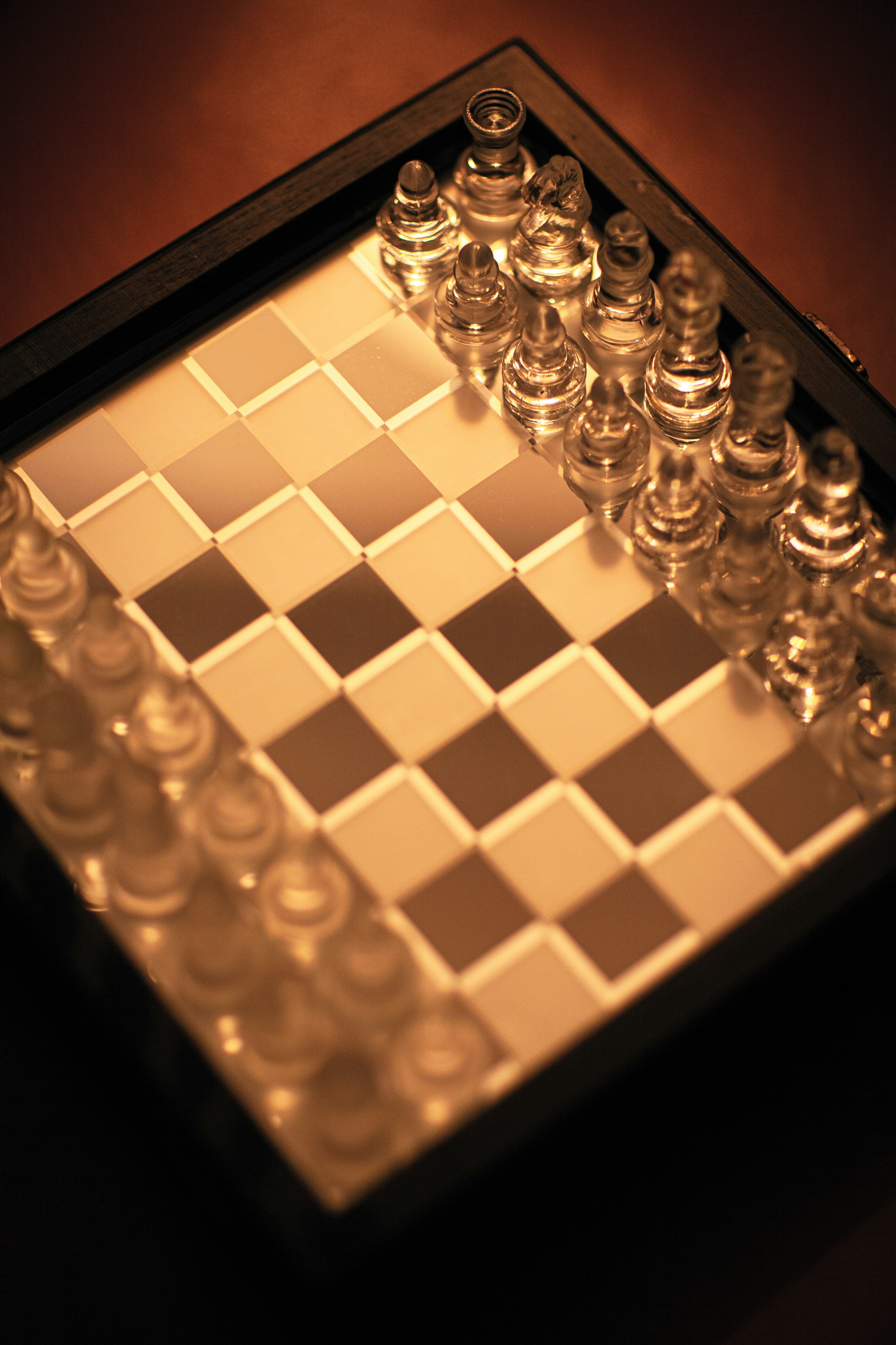 Amber-Glow Chess: Translucent Pieces Framing a Tilted Glass Board