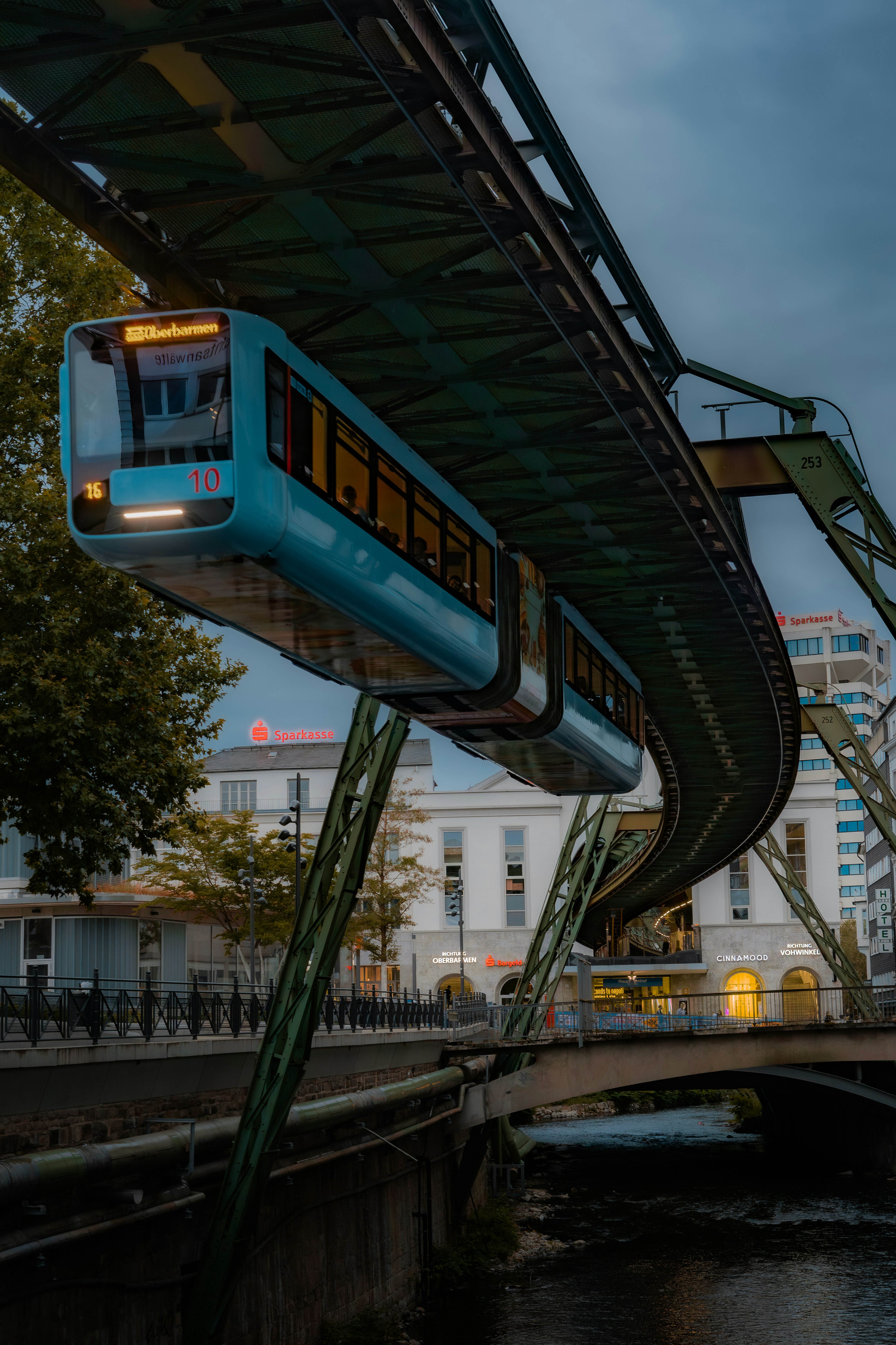 A suspended train travels above a city.