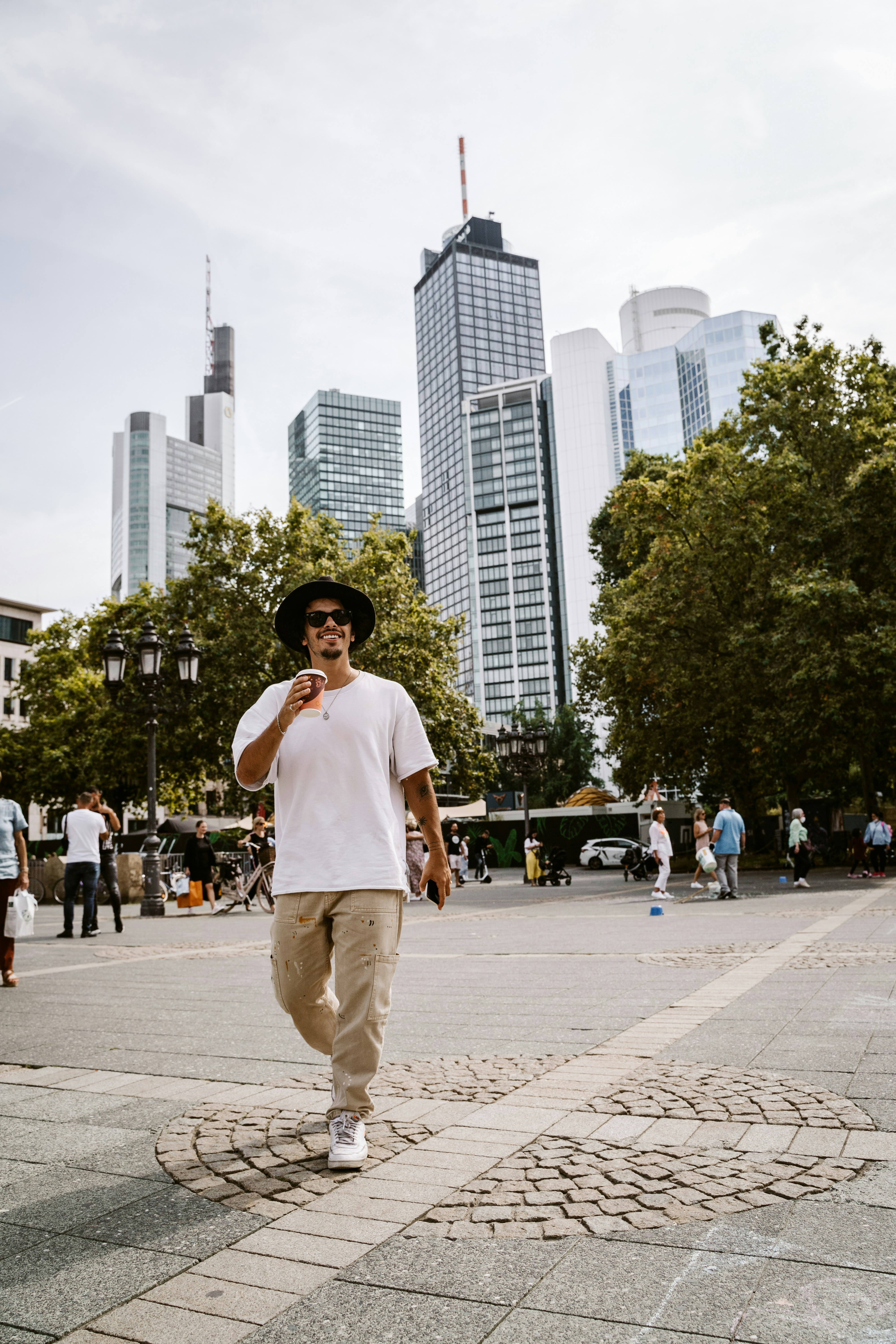 City stroll: the coffee-handled stride under a glass skyline