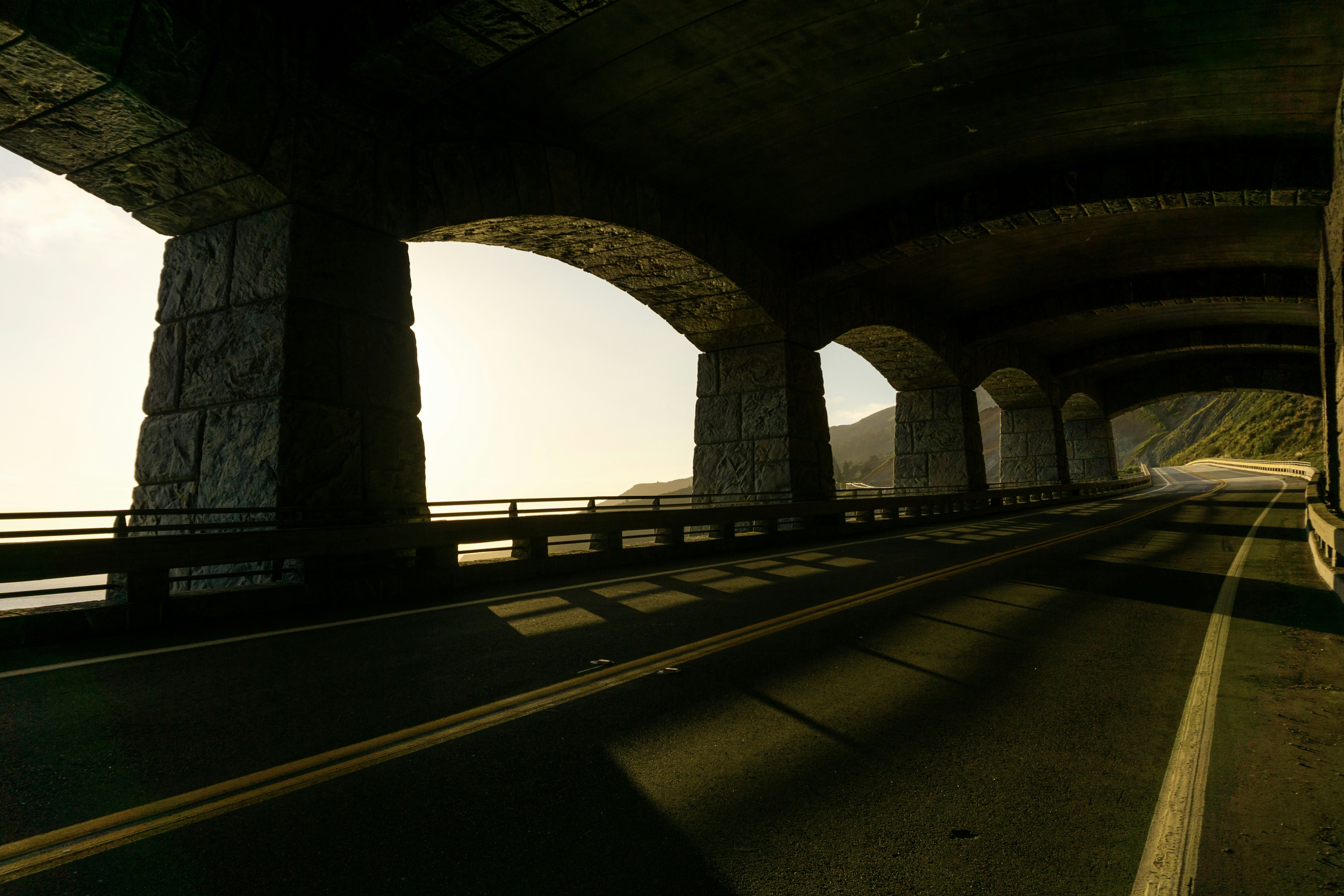 Shadowed Arches Over the Coastline Road at Dusk