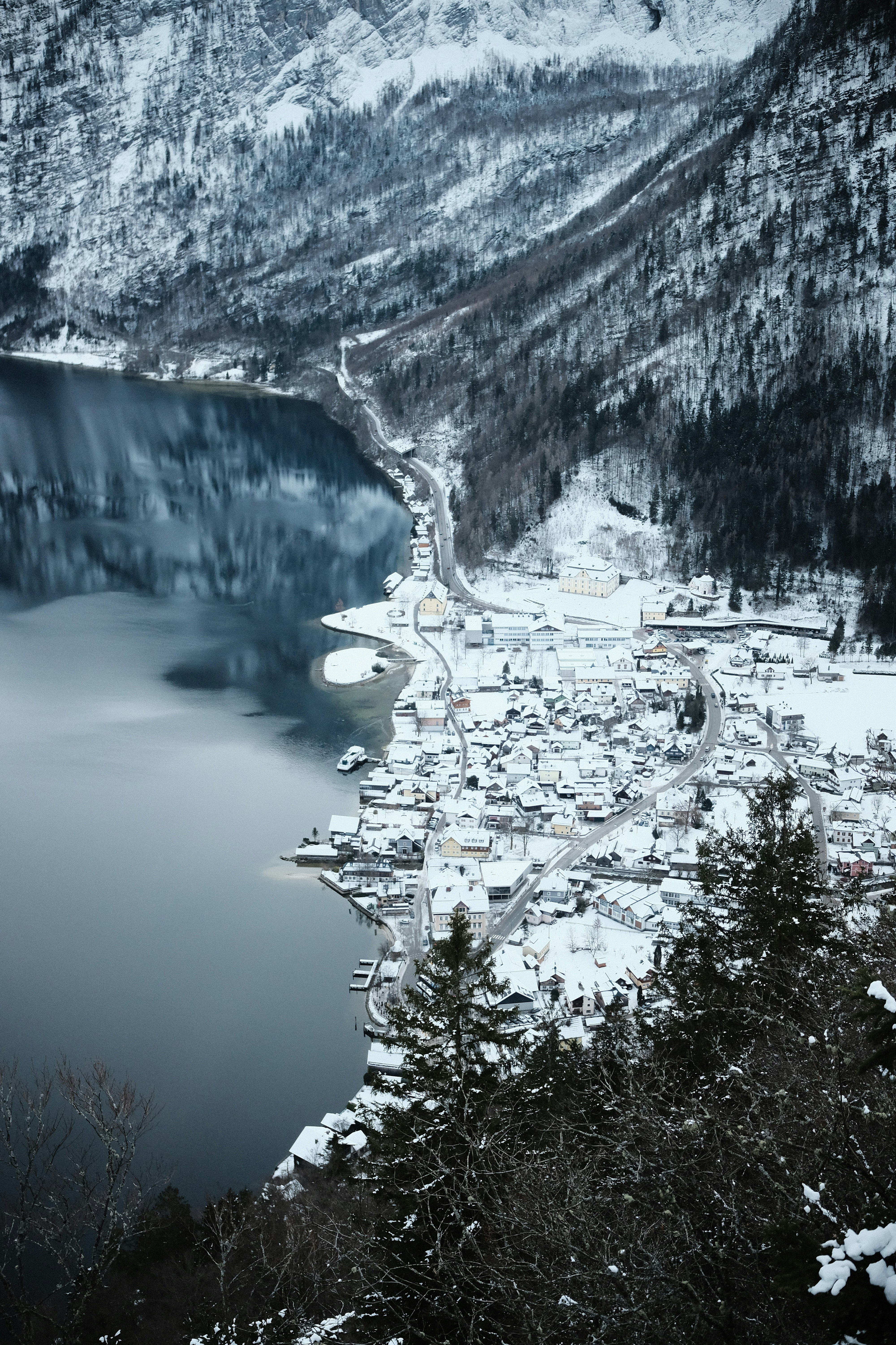 A Snow-Capped Village Clings to a Fjord's Edge