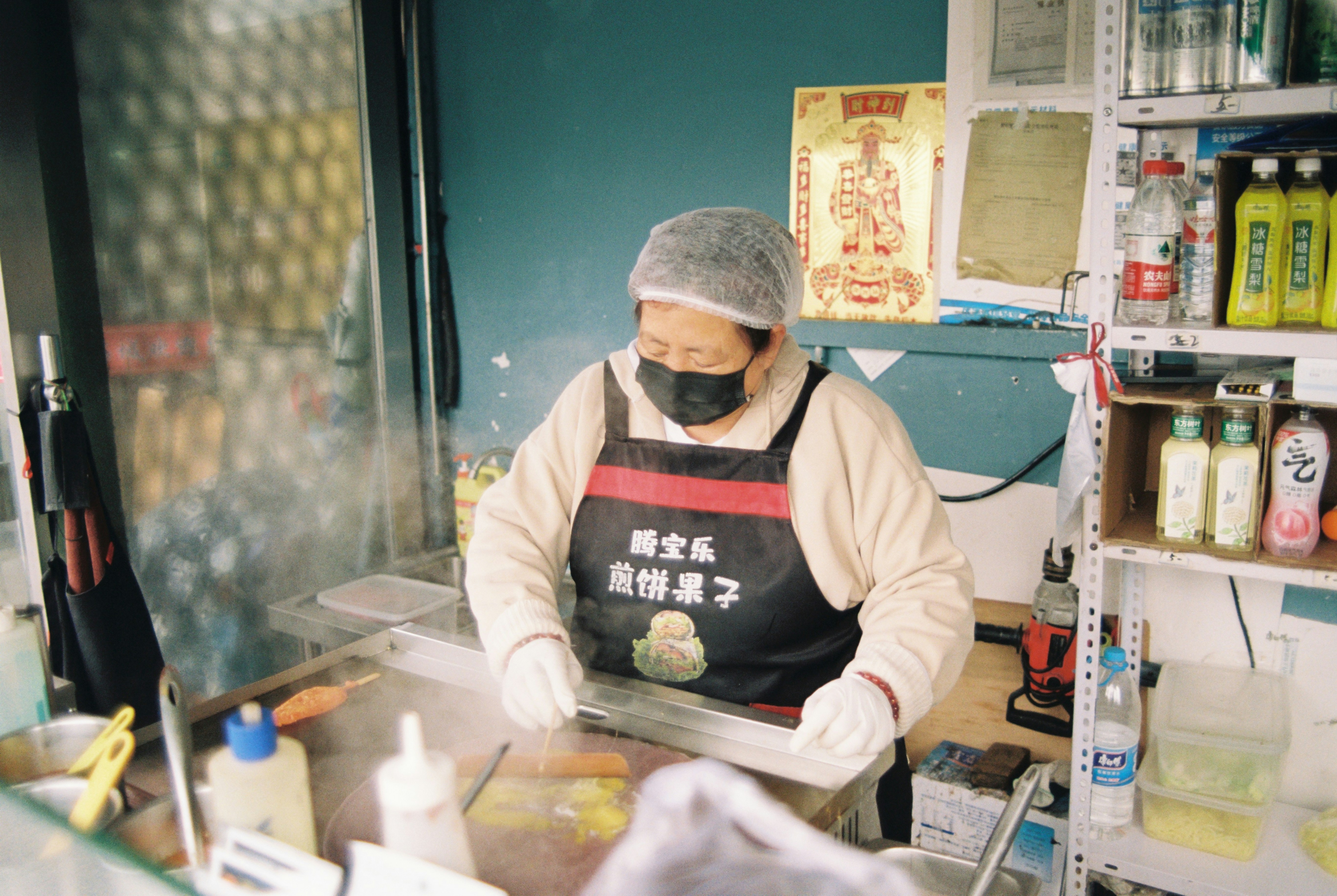 A street vendor prepares food at a stall. photo – Free Film photography ...