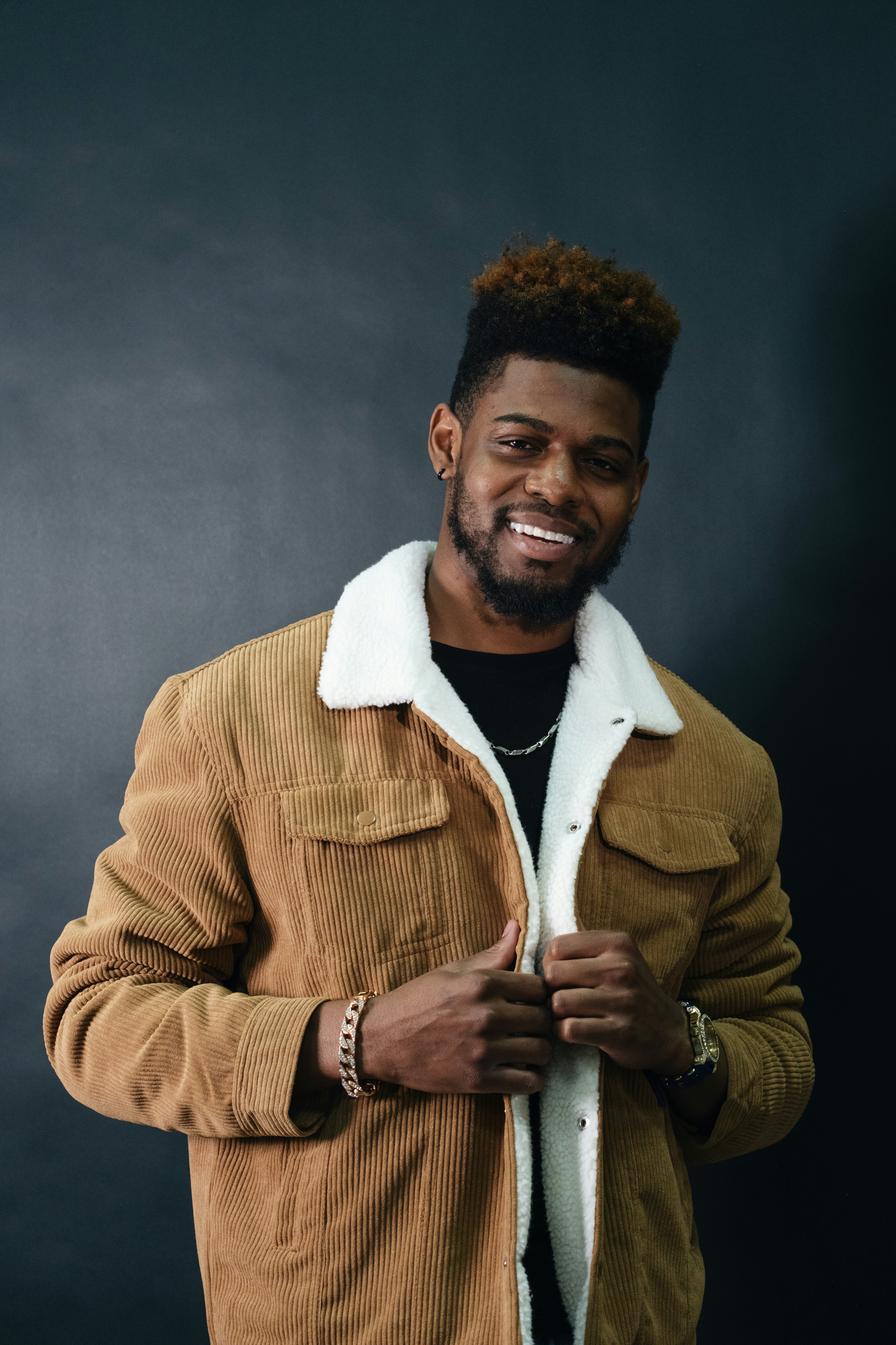 A smiling man poses in a stylish jacket. photo – Free Man Image on Unsplash