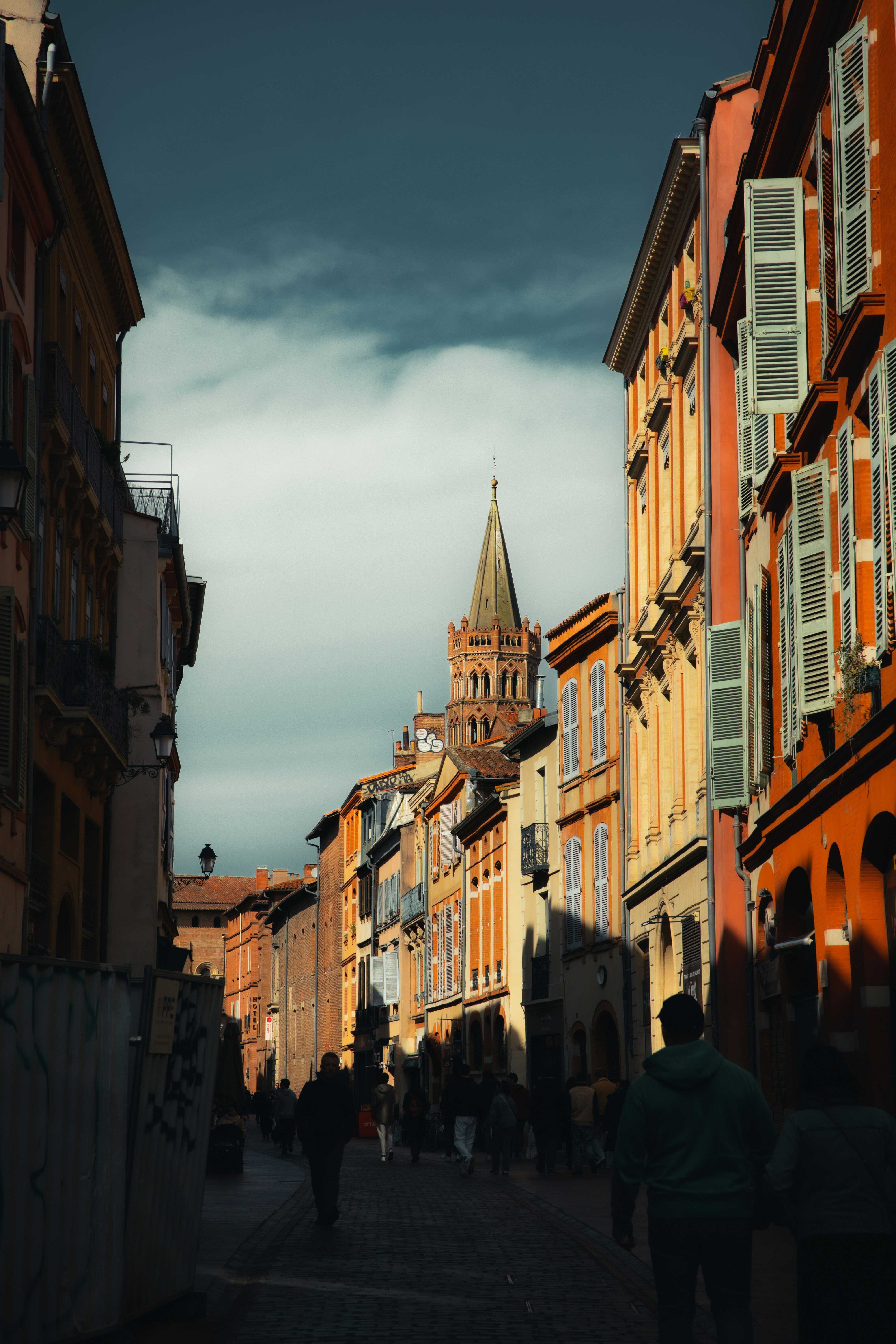 A narrow, colorful street leads to a steeple. photo – Free Building ...