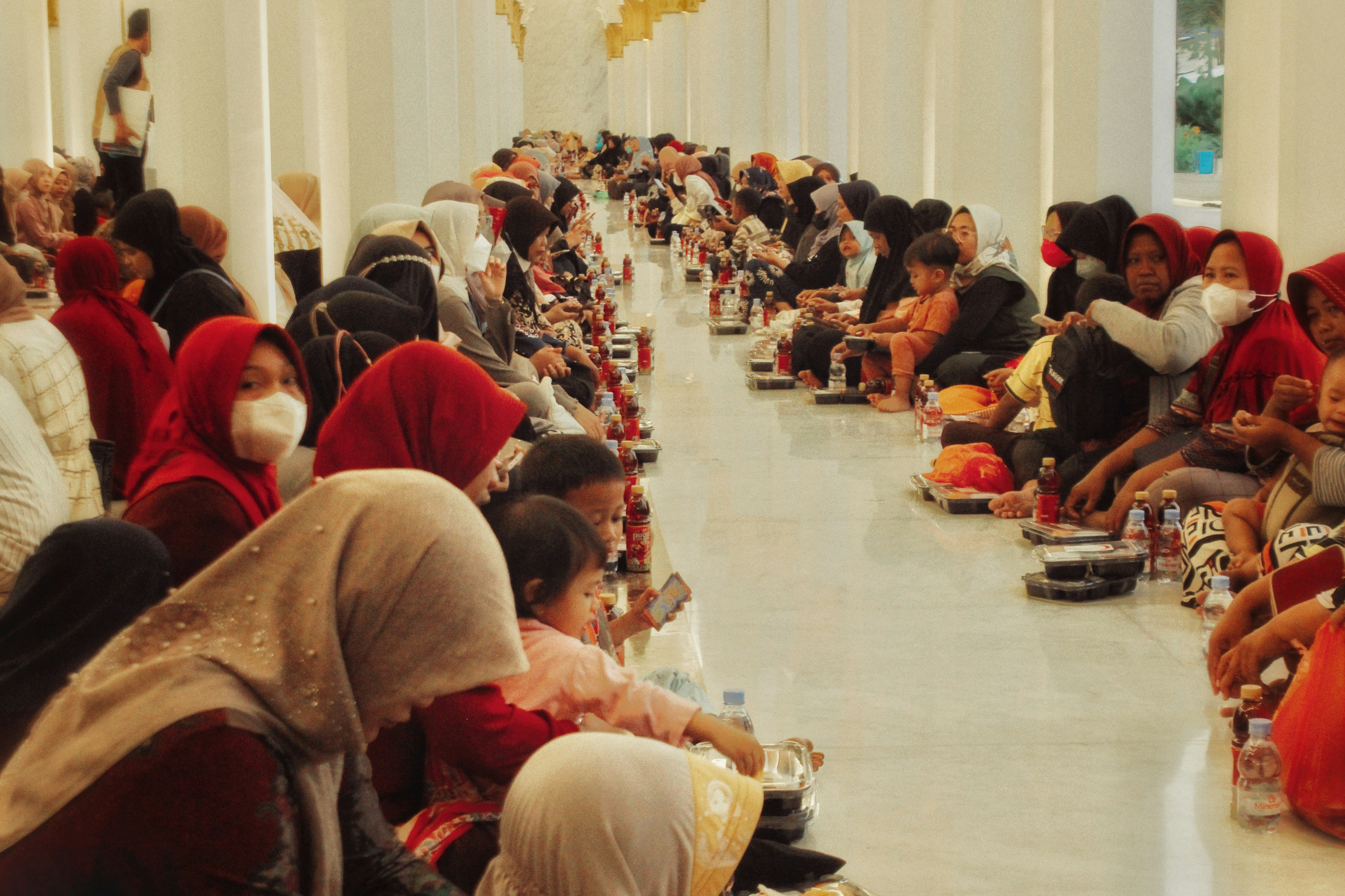 Buka Puasa Bersama Perempuan di Masjid Raya Sheikh Zayed Solo | People are seated on the floor in a bright hall.