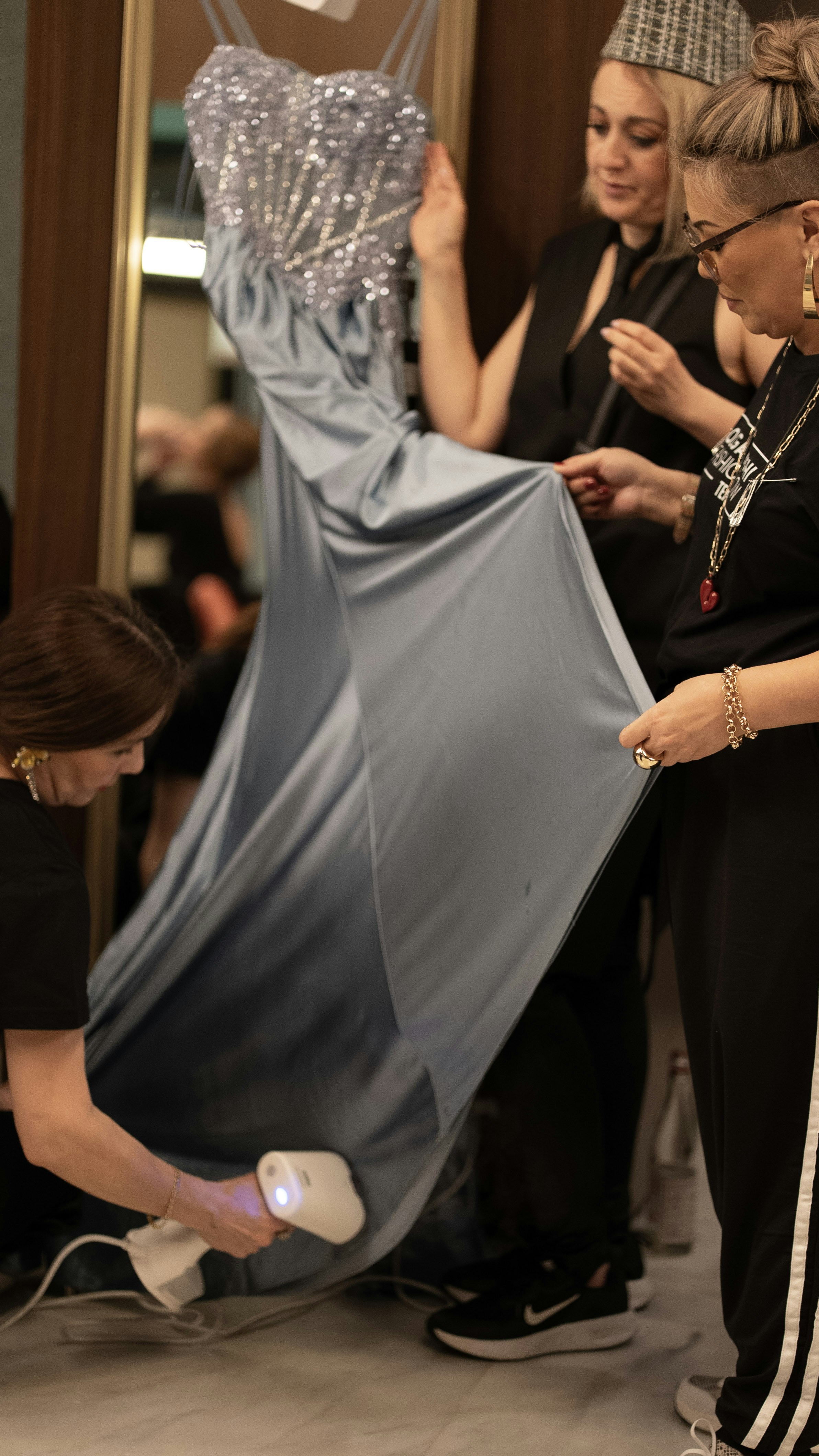 Backstage Unfolding: A Beaded Midnight-Blue Gown Takes Shape