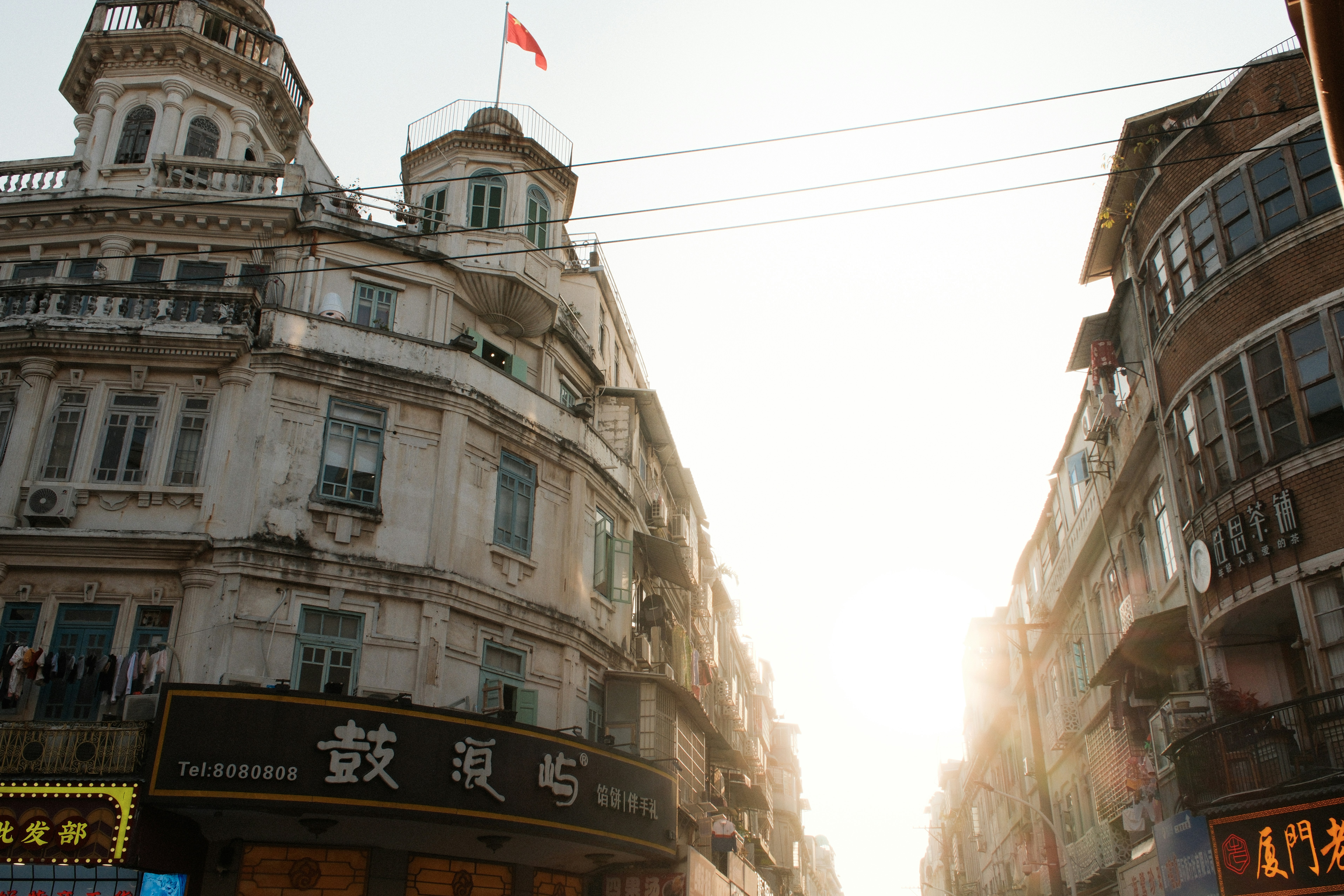 Sunlit historic buildings lining a vibrant city street.