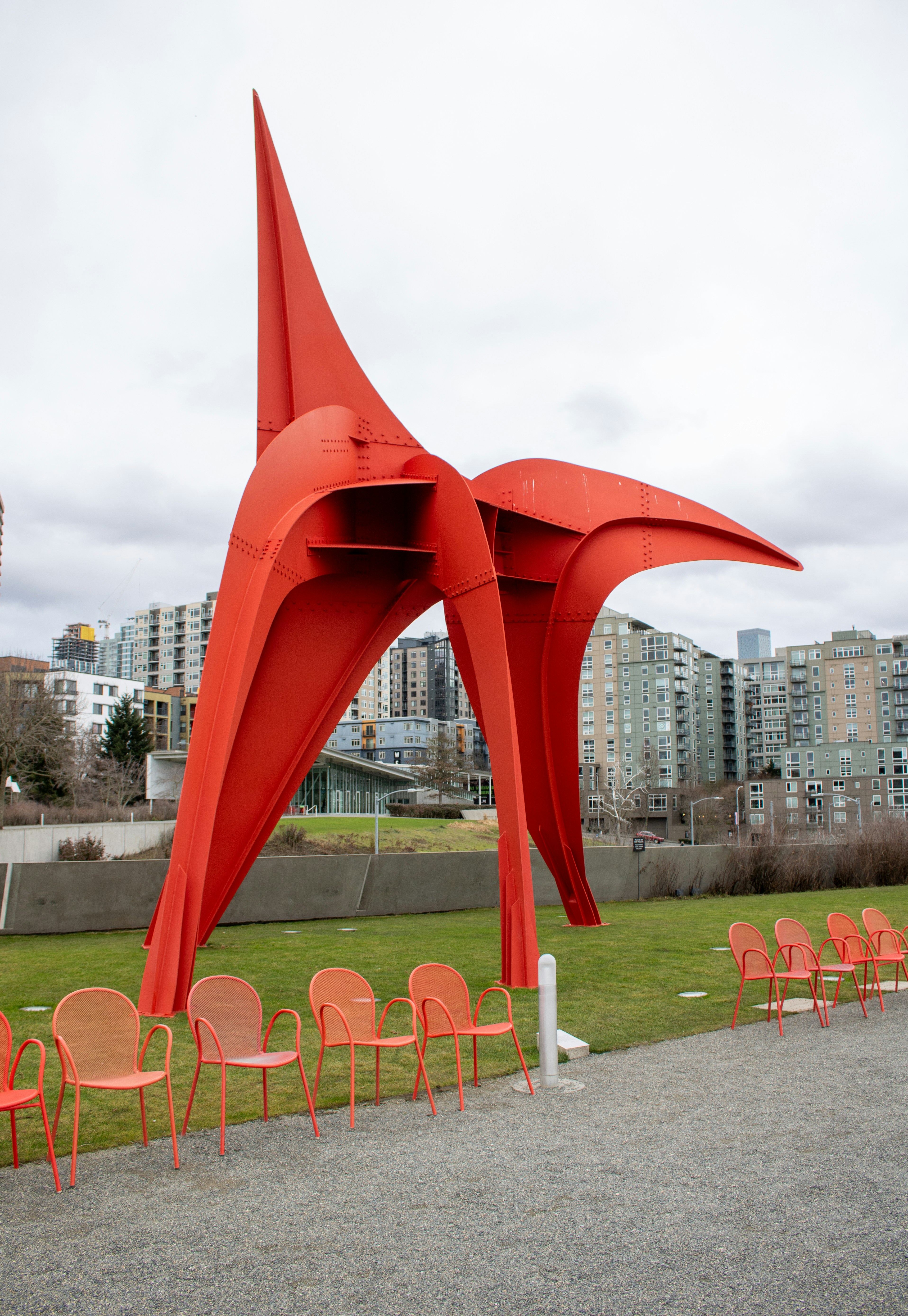 Crimson Arc: Red Steel Wings Over a City Park