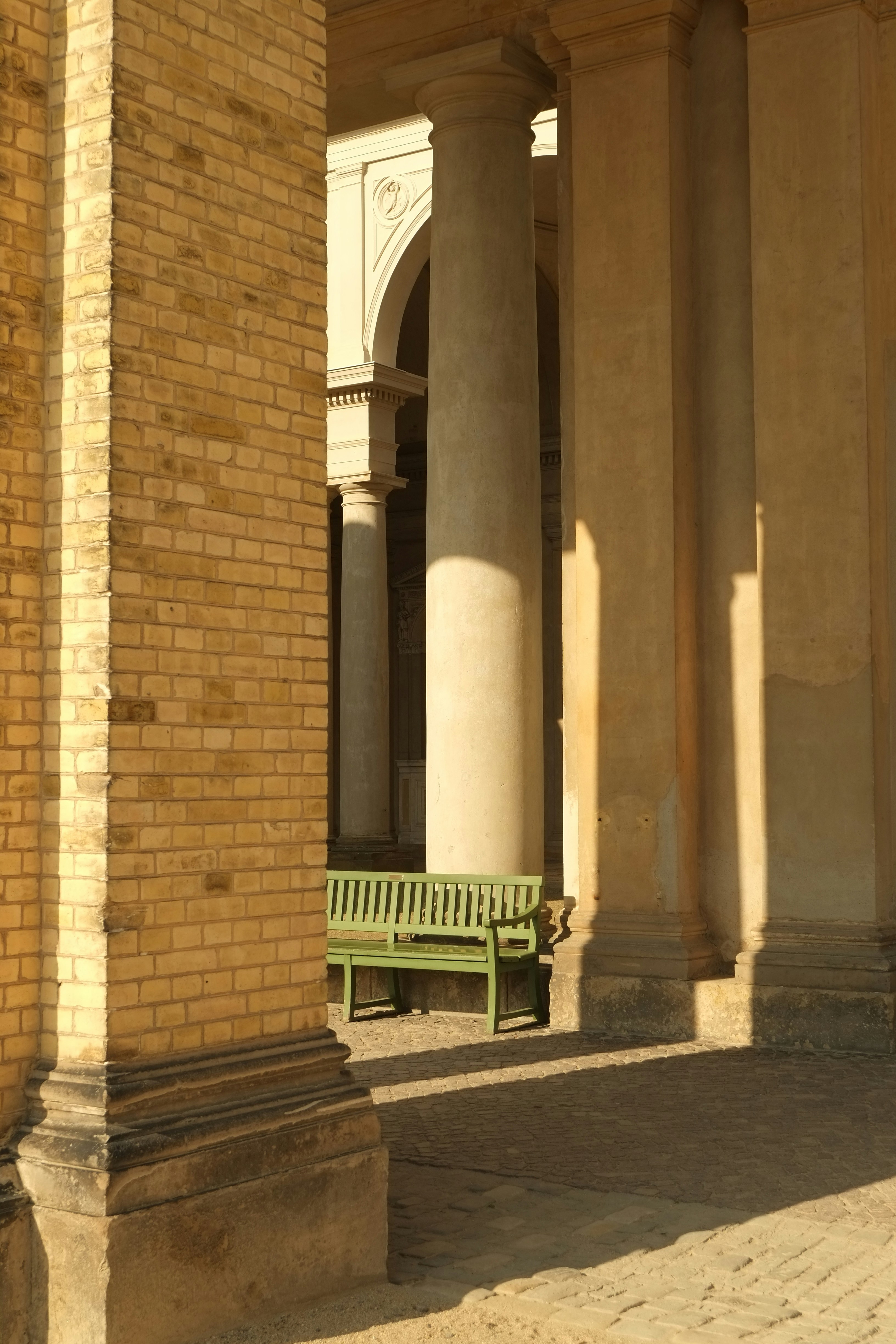 Green Bench in Sunset Colonnade: A Quiet Dialogue of Light and Stone