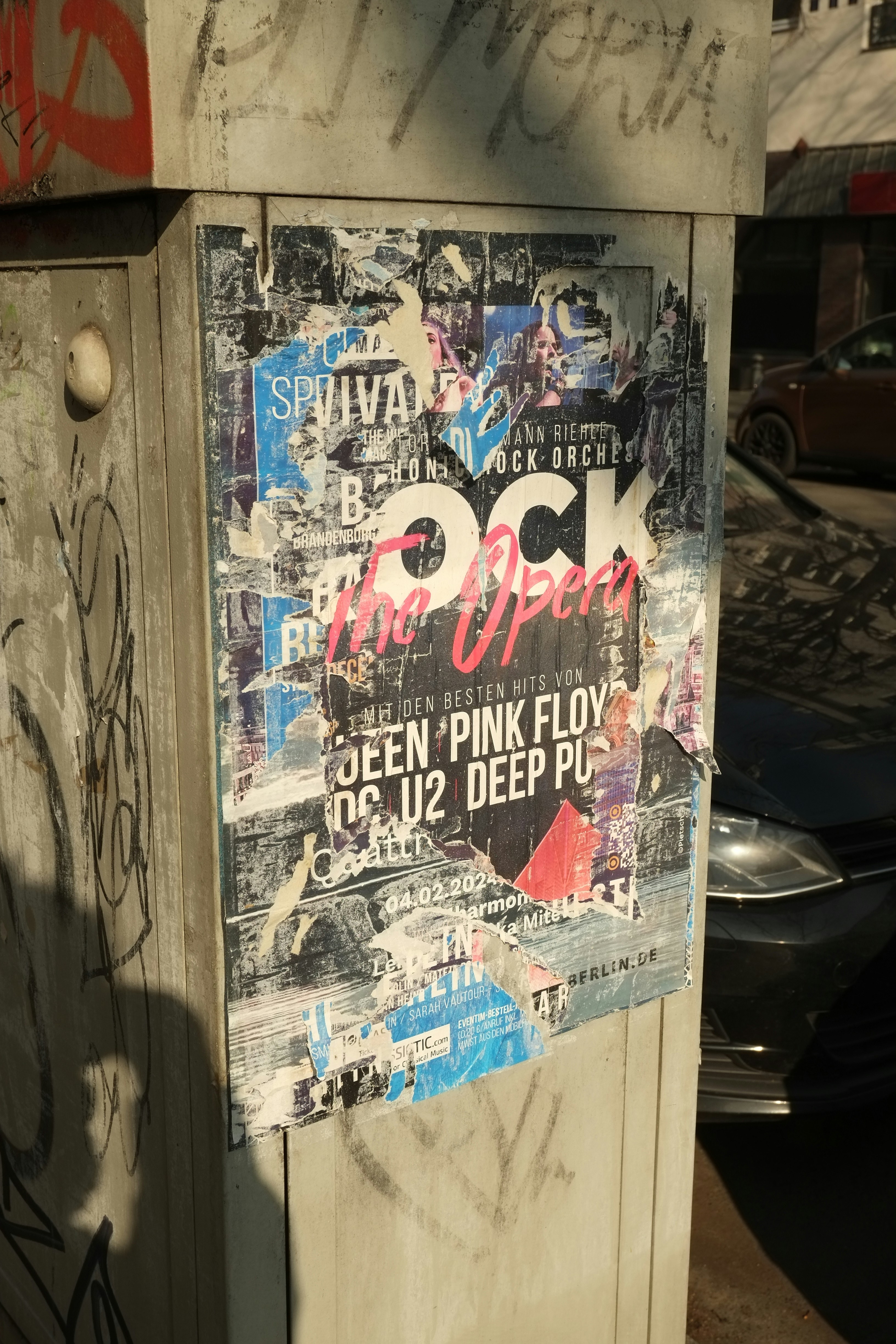 Poster-Pillared Graffiti: A Weathered Street Orchestrates Color and Decay