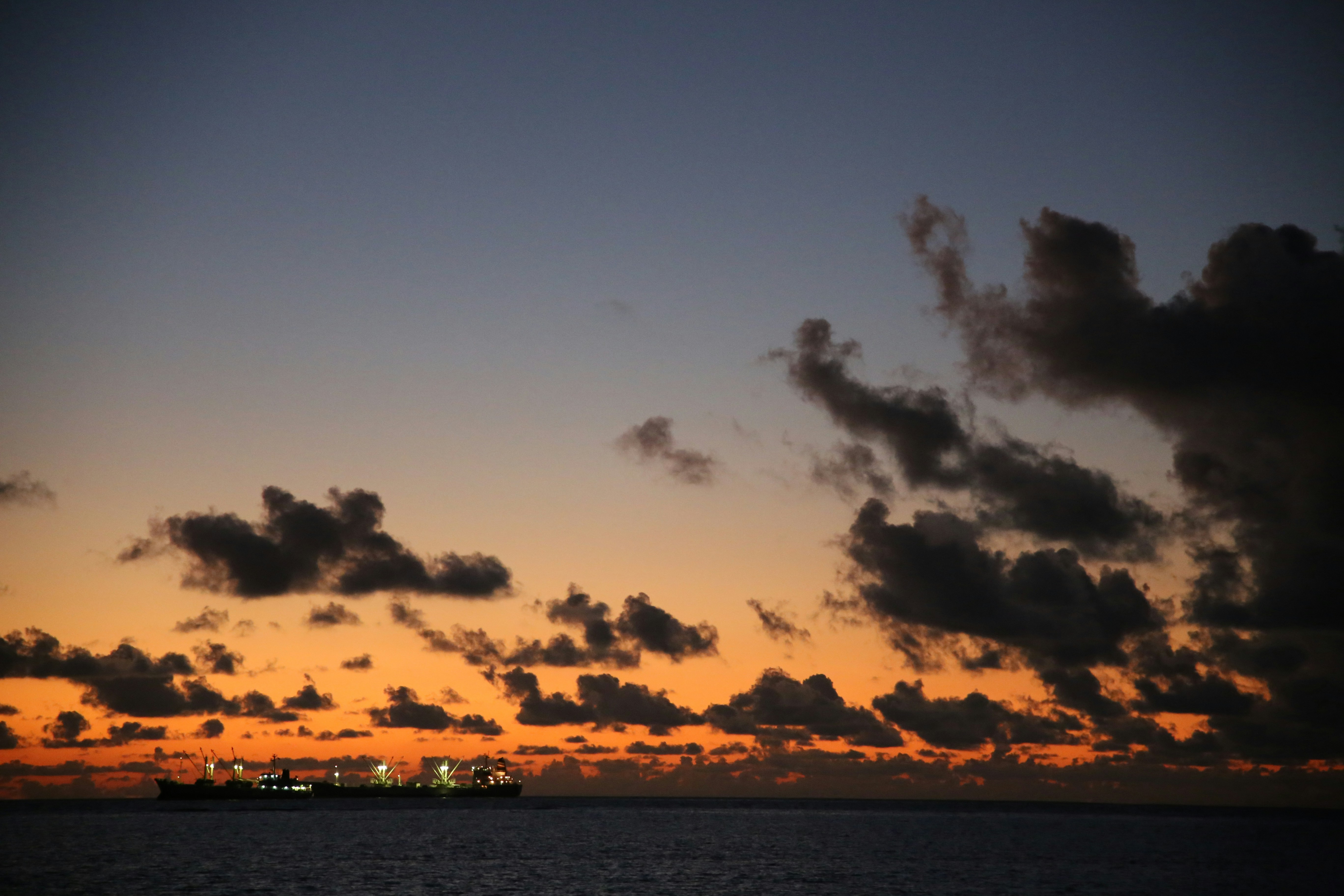 Dusk Vessel on a Quiet Horizon beneath Ember Clouds