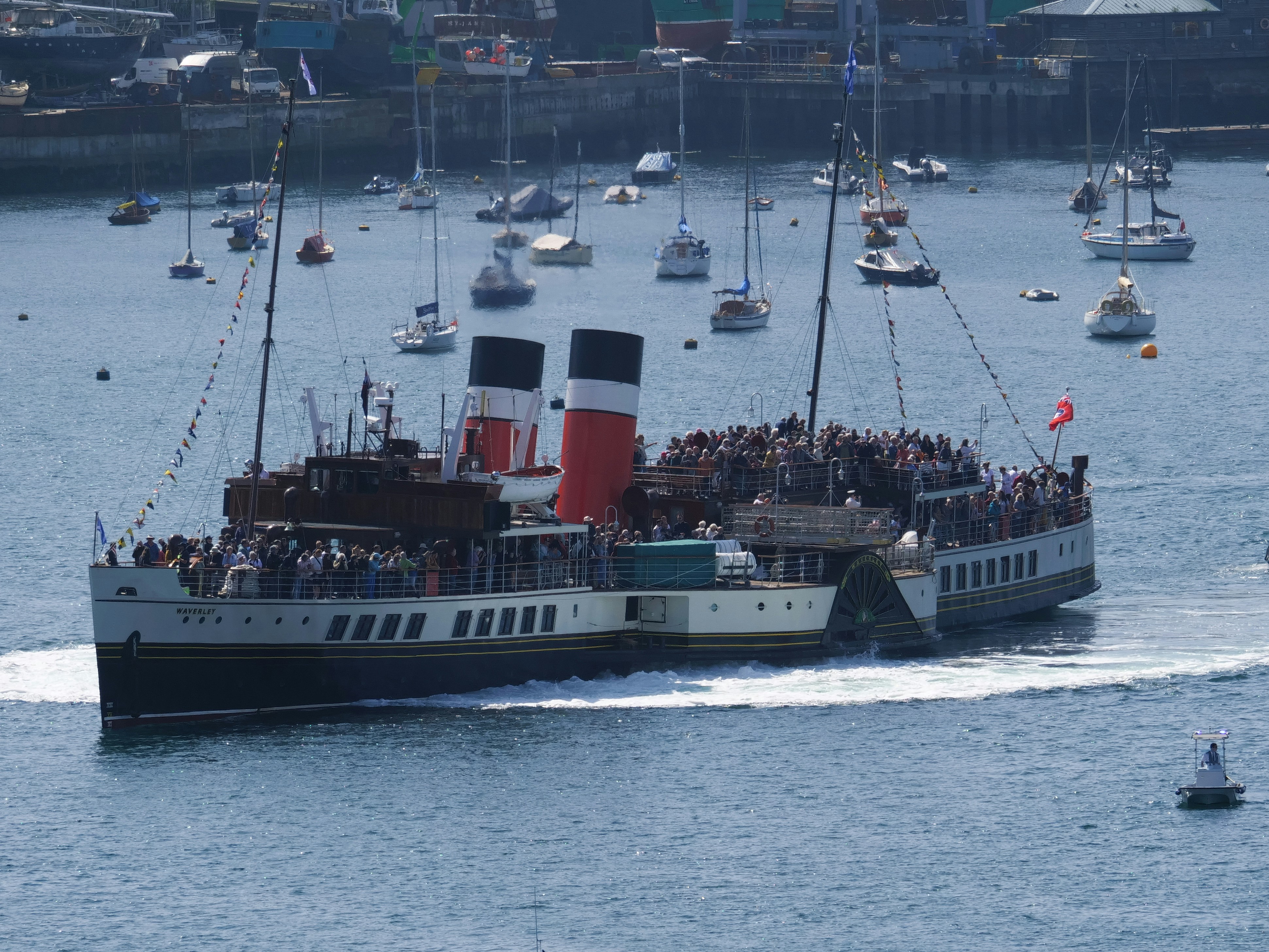 Majestic Paddlewheel Steamer Sails Through a Harbor Ringed with Masts