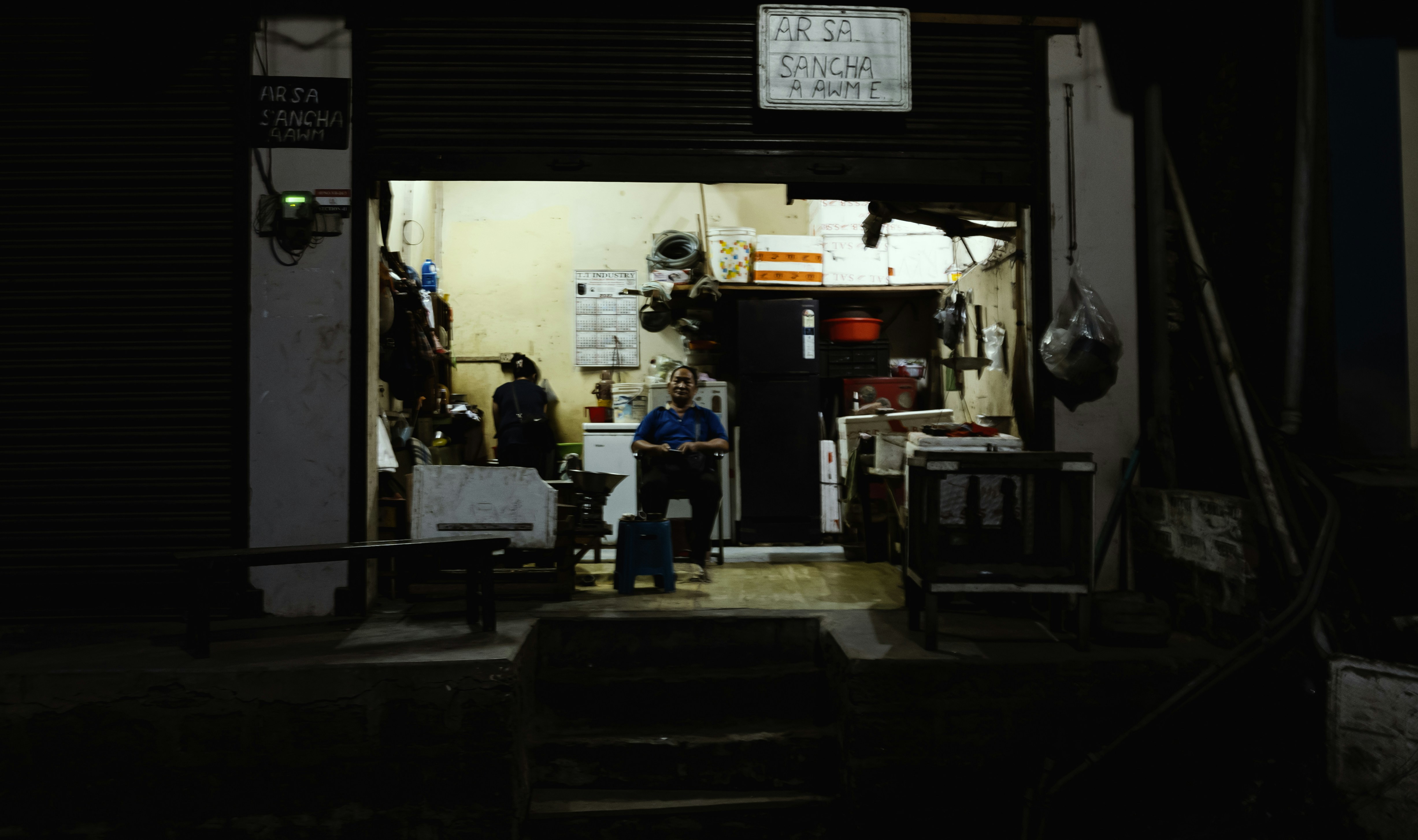 A dimly lit store with a person inside. photo – Free Light Image on ...