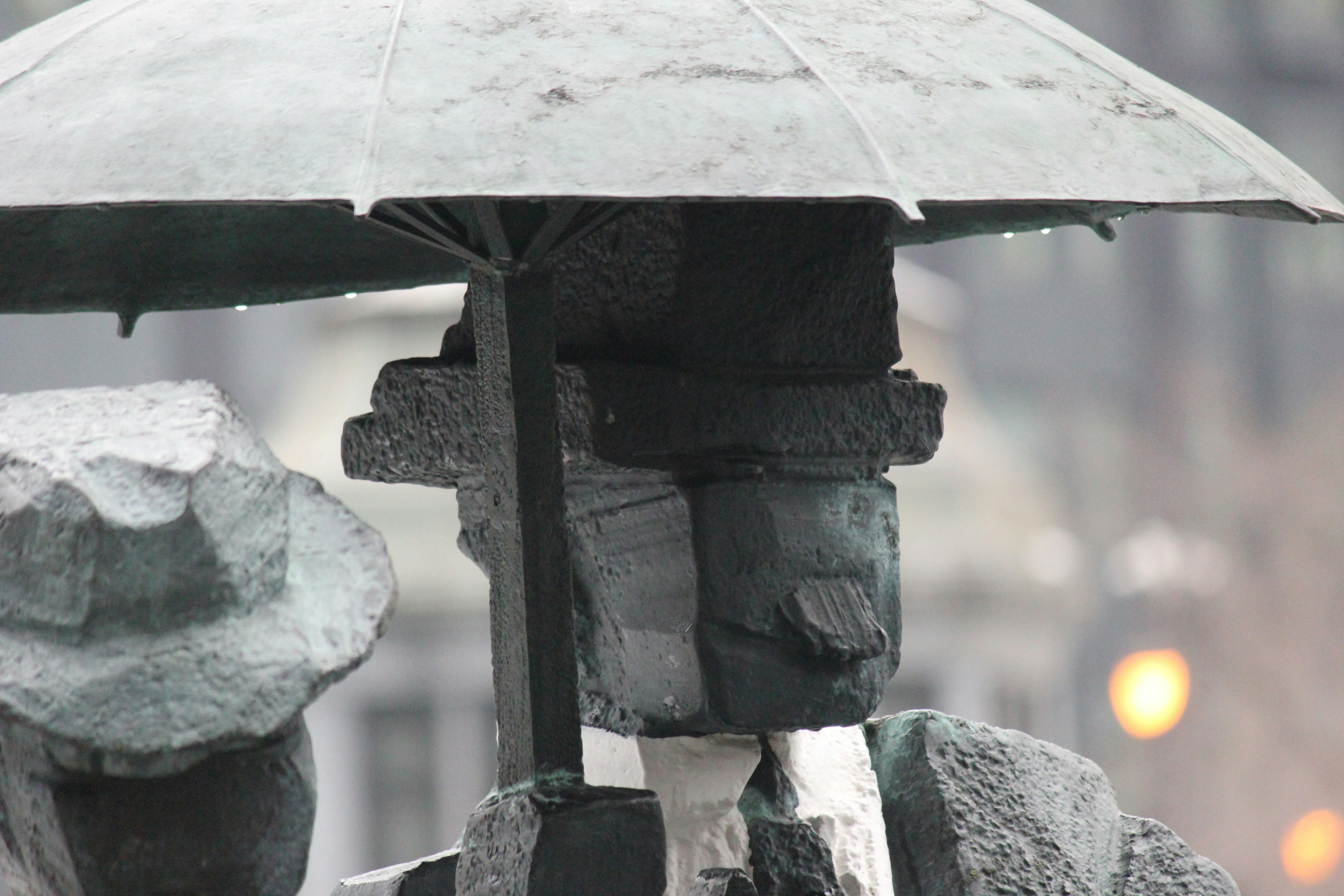 Storm-Sculpted Stone: An Umbrella Guard in the City Square