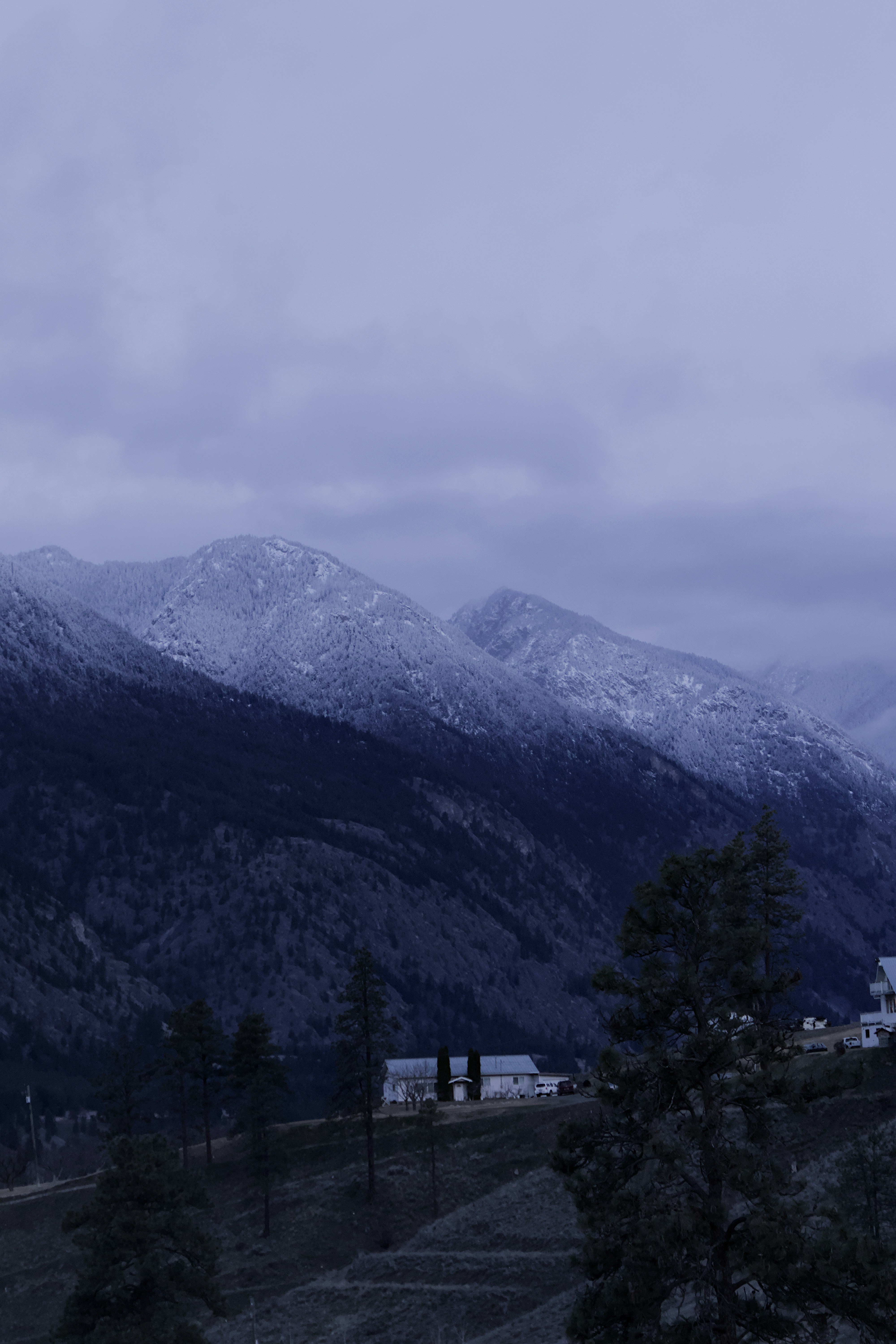 Snowy mountains under a cloudy, overcast sky.