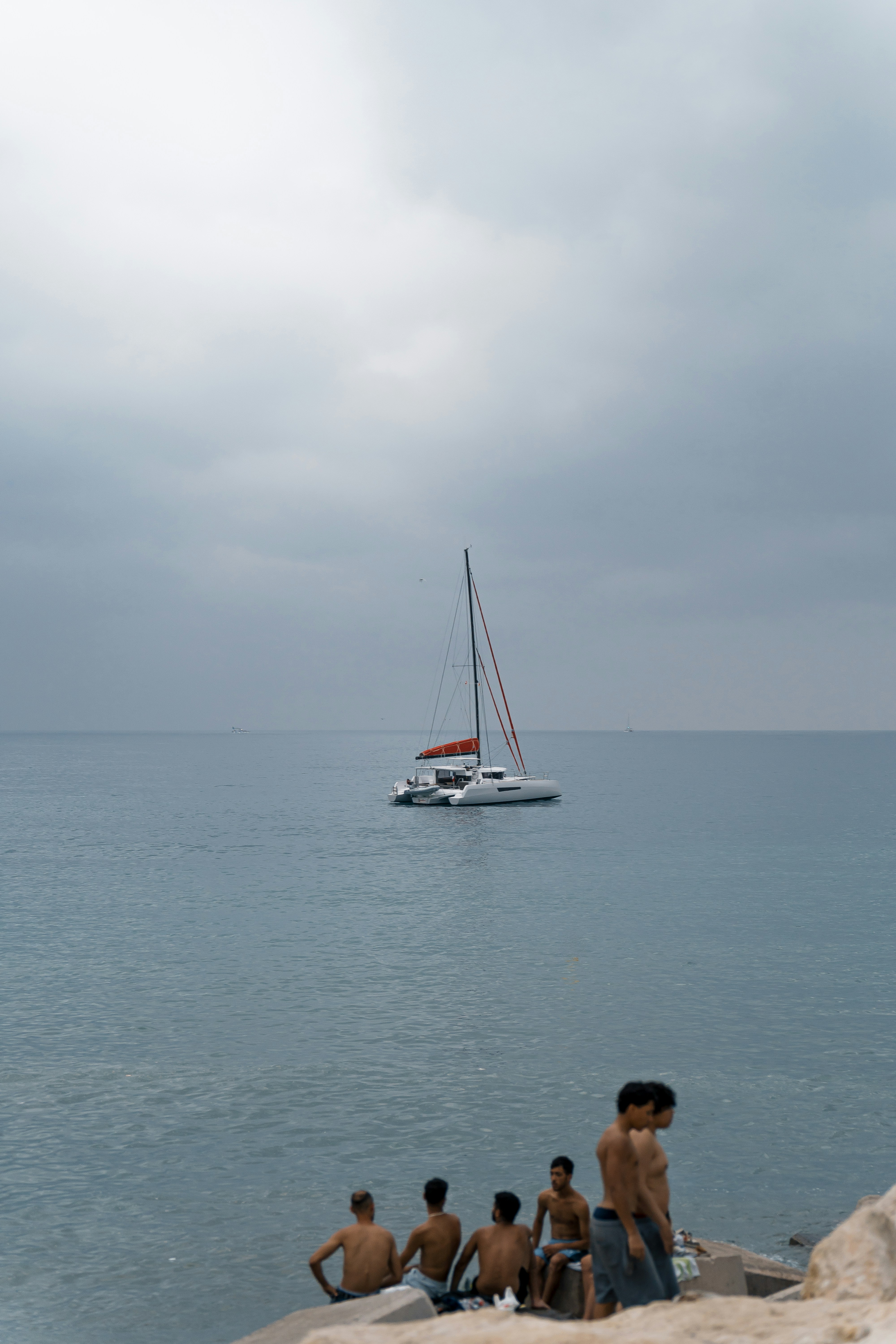 Sailboat Quietly Adrift Beneath Storm-Broken Skies