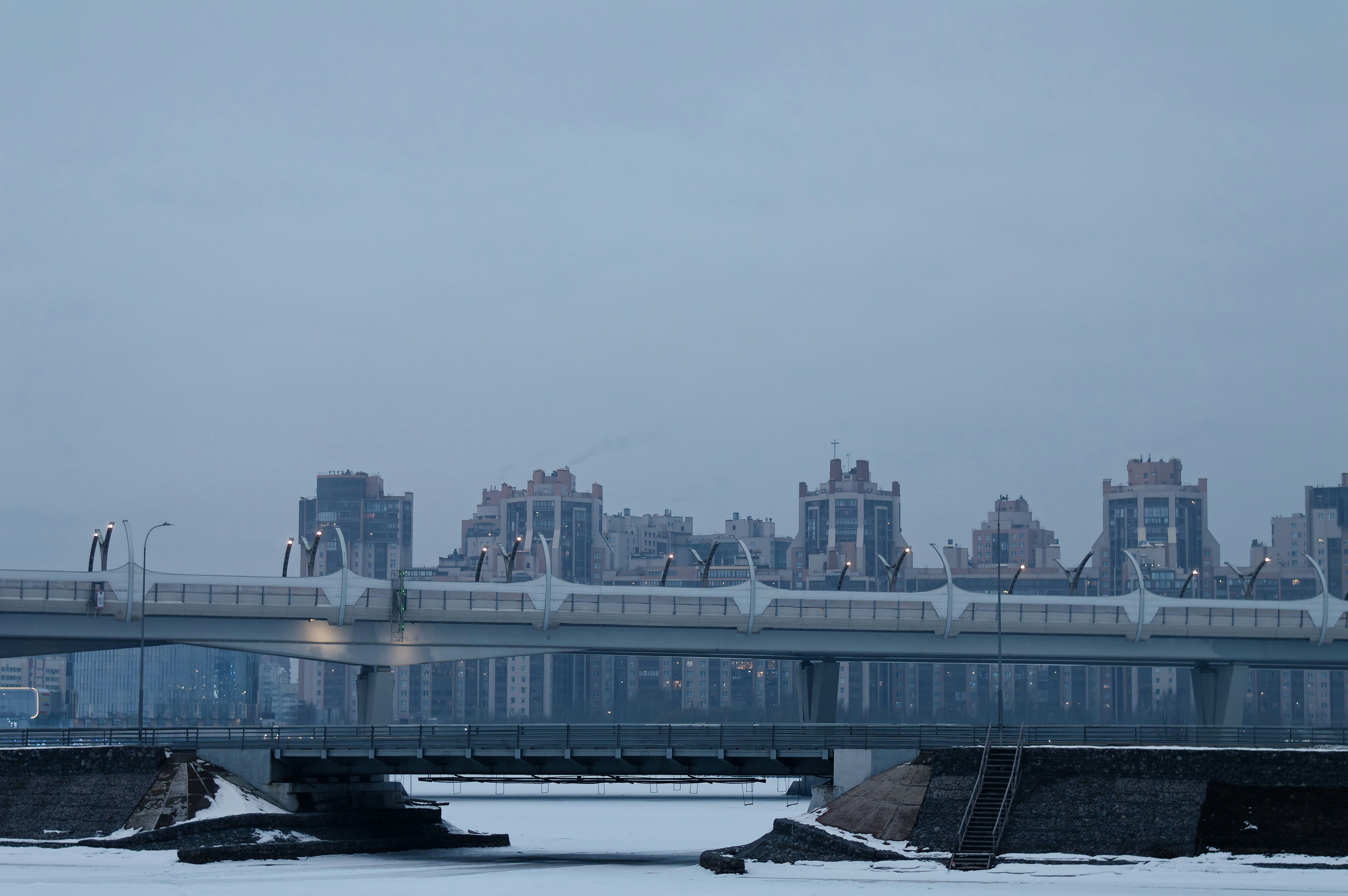 A frosty cityscape with a bridge and buildings.