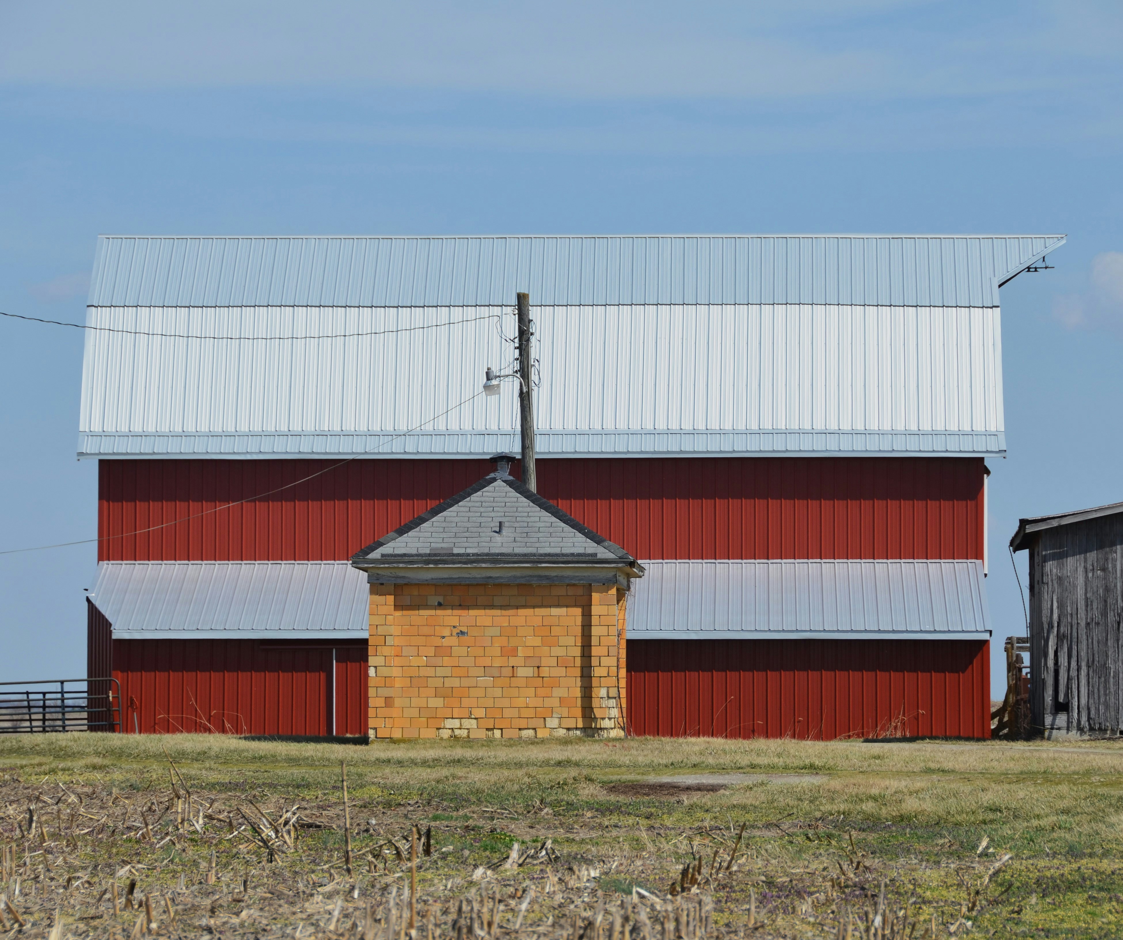 Brick Annex Beneath Tiered Red Barns