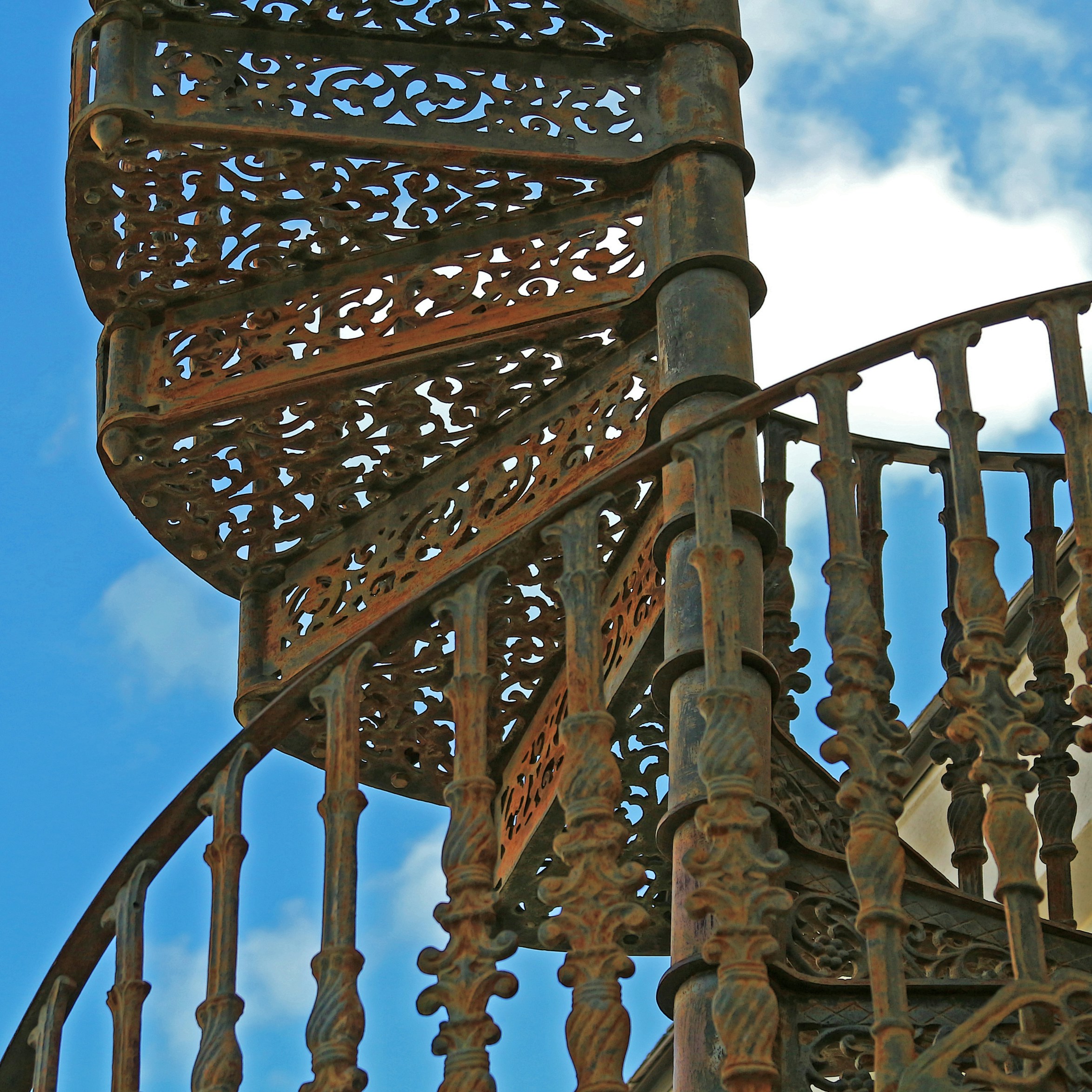 Iron Lace Ascends: A Rusted Spiral Staircase Reaching for the Sky