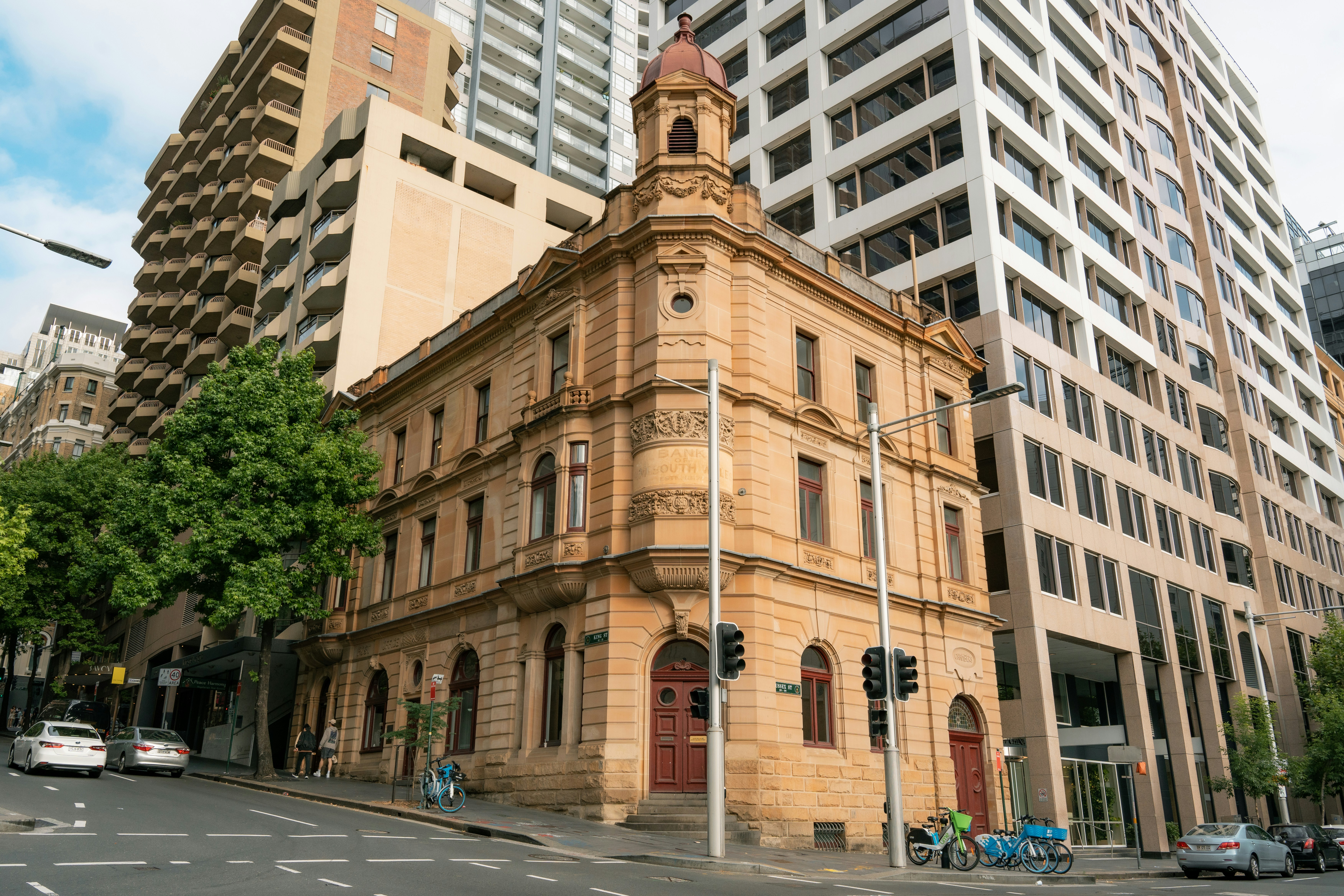 A historic building stands among modern skyscrapers. photo – Free Car ...