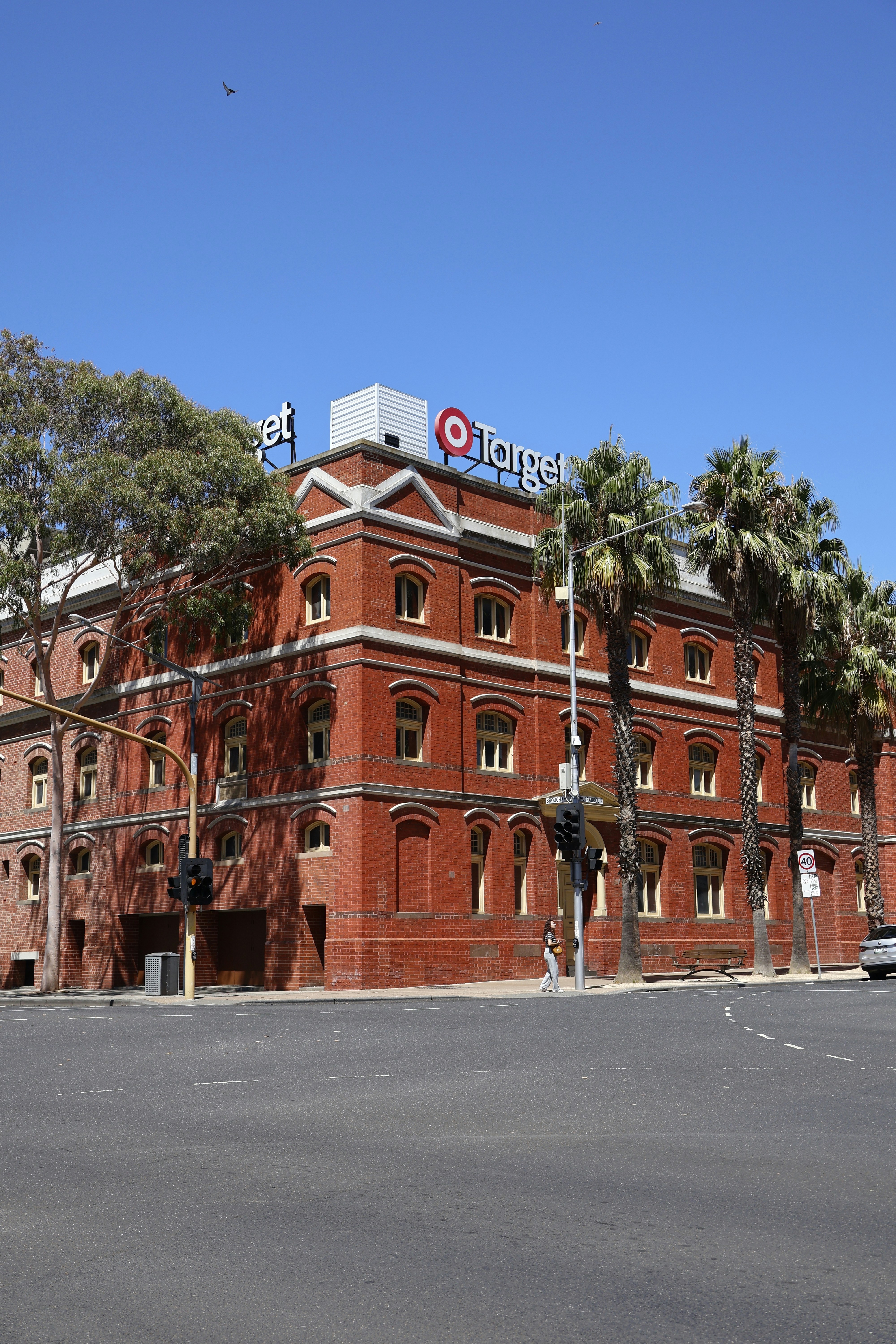 Red Brick Corner: The Tallest Windowed Facade Beneath Palm Trees
