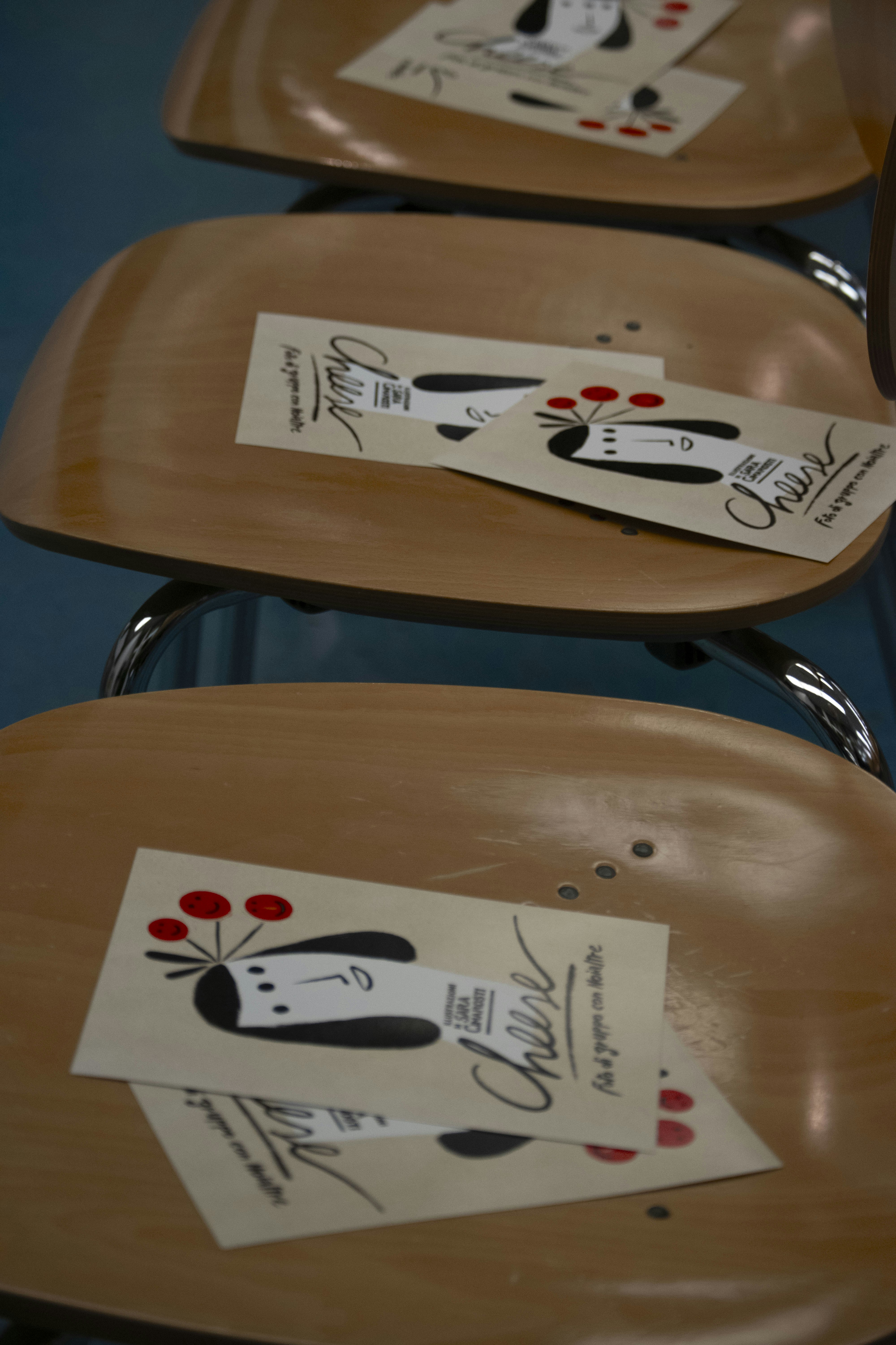 Invitations are placed on wooden chairs.