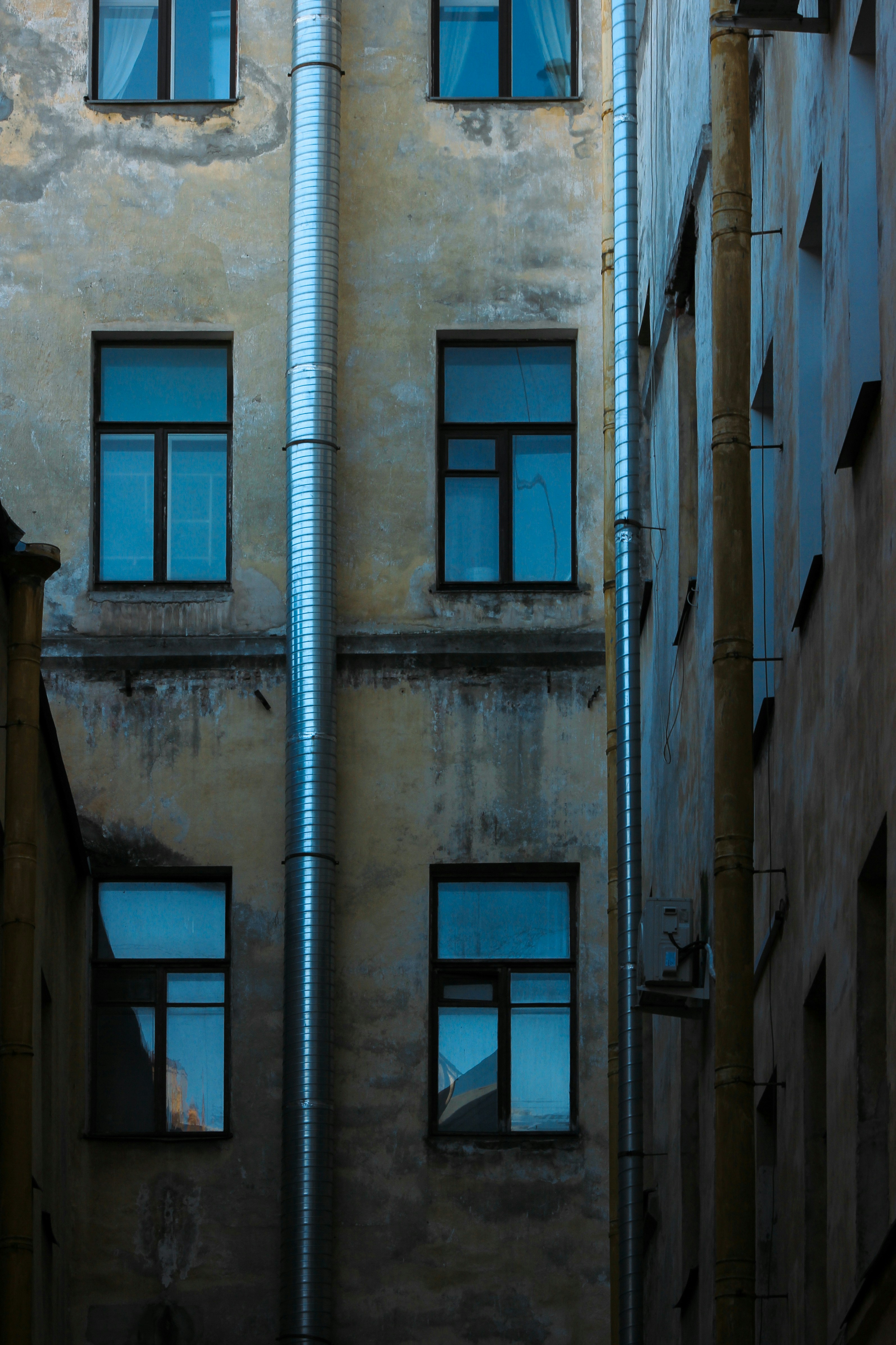 Buildings with windows and pipes, captured from below. photo – Free ...