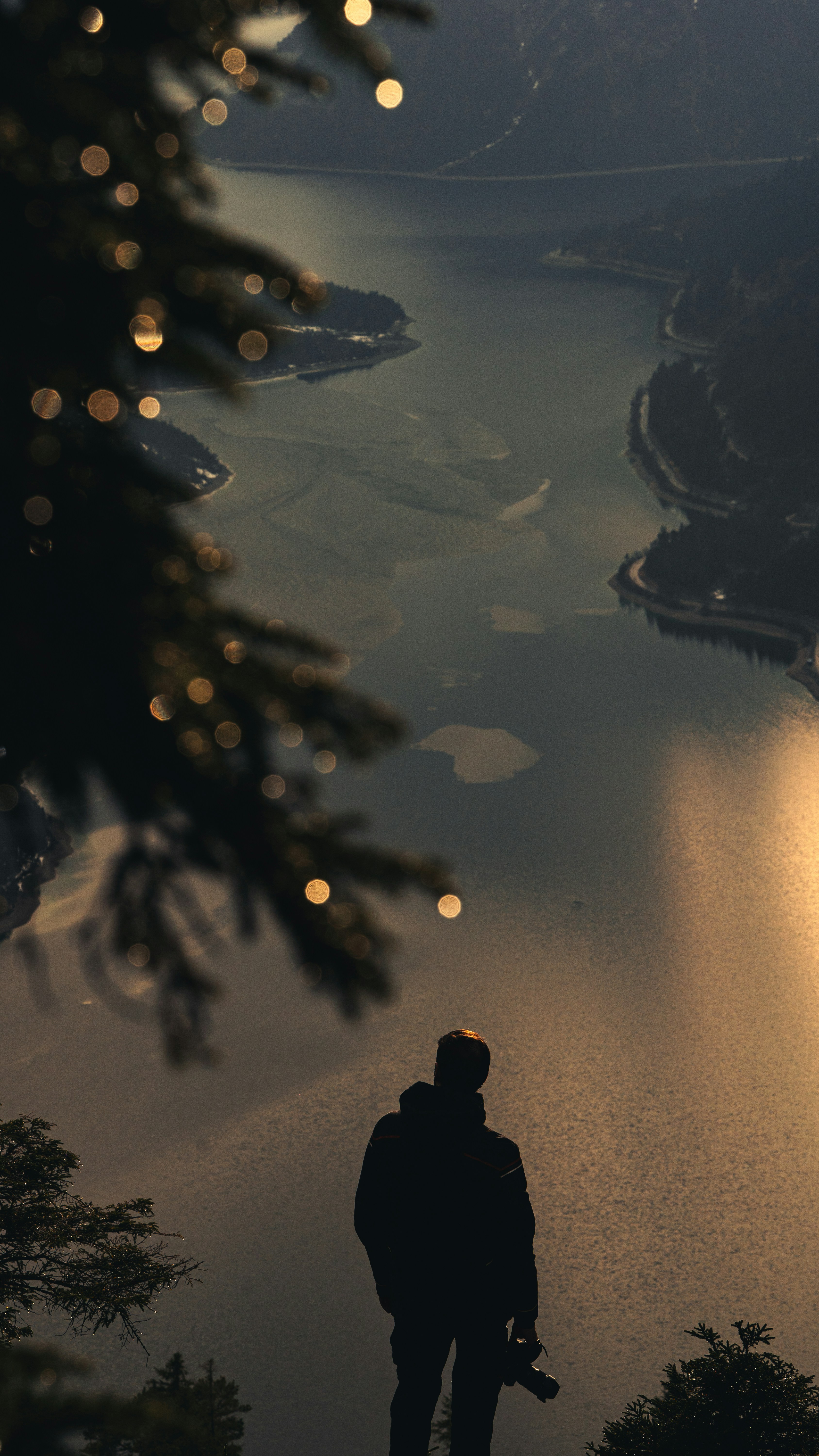 Silhouette at Dusk: A Photographer's Quiet Vantage over a Meandering River