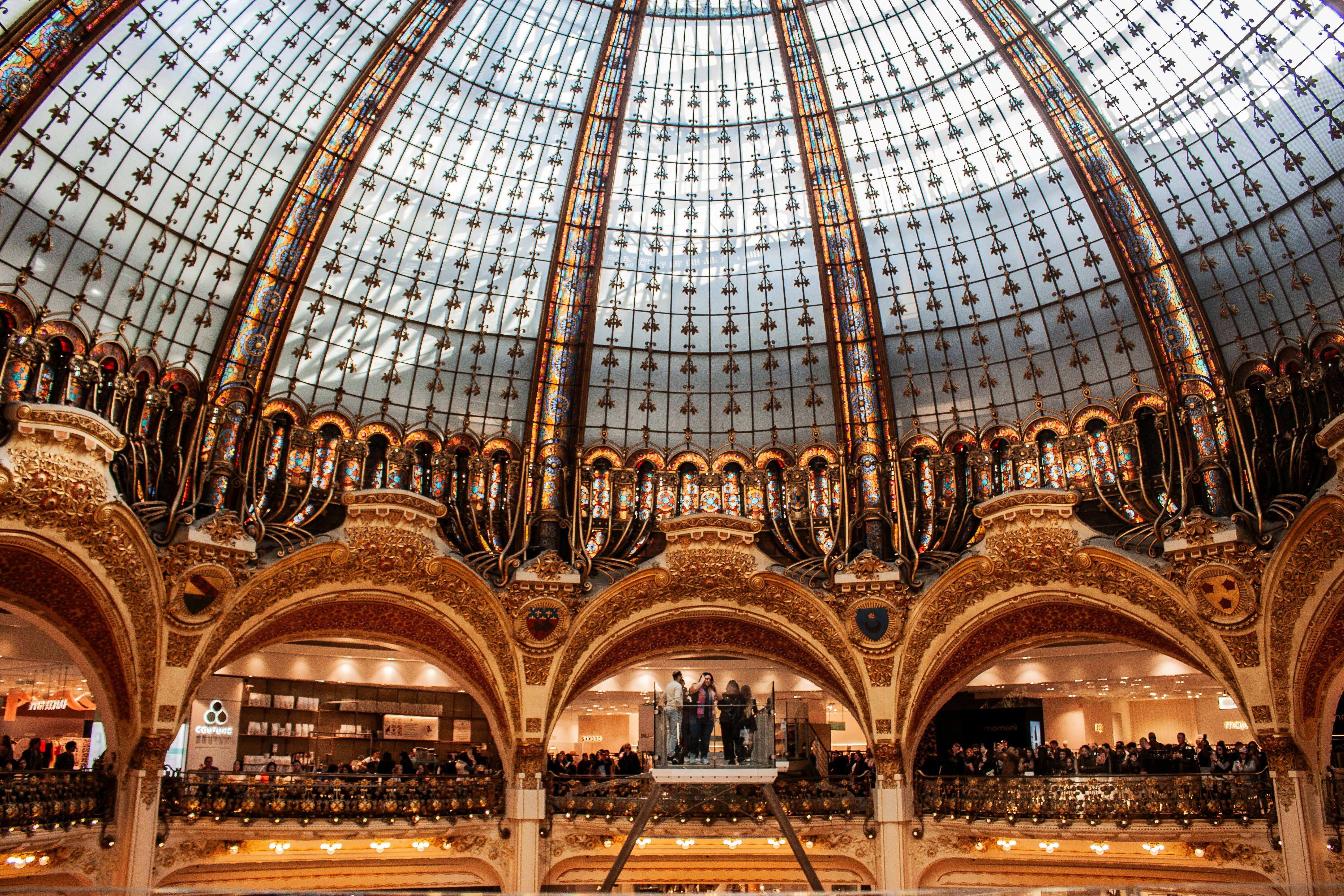 Intricate stained glass dome with ornate arches in a grand interior space.