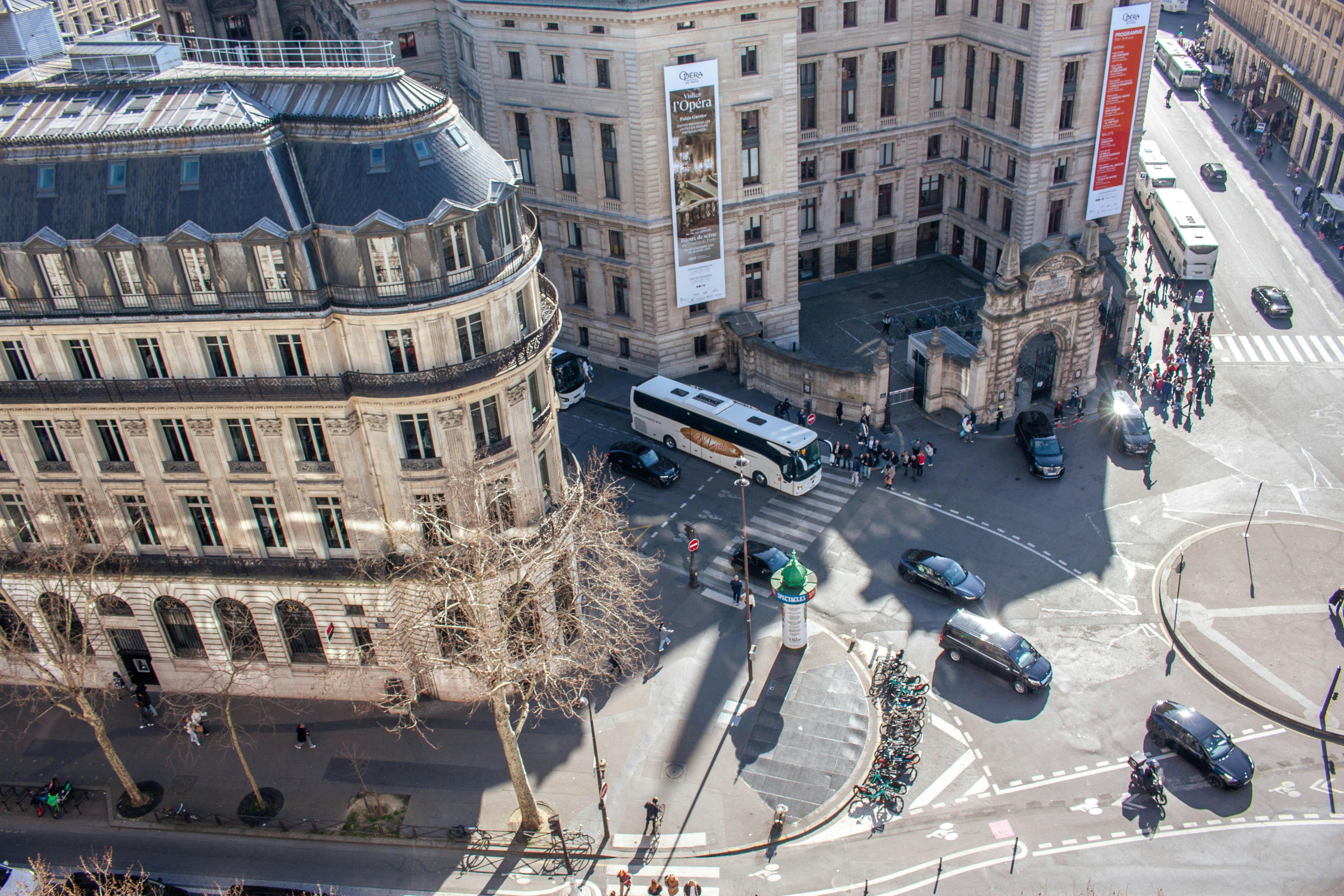 High-angle view of a bustling city intersection with vehicles navigating curved streets amidst historic architecture.