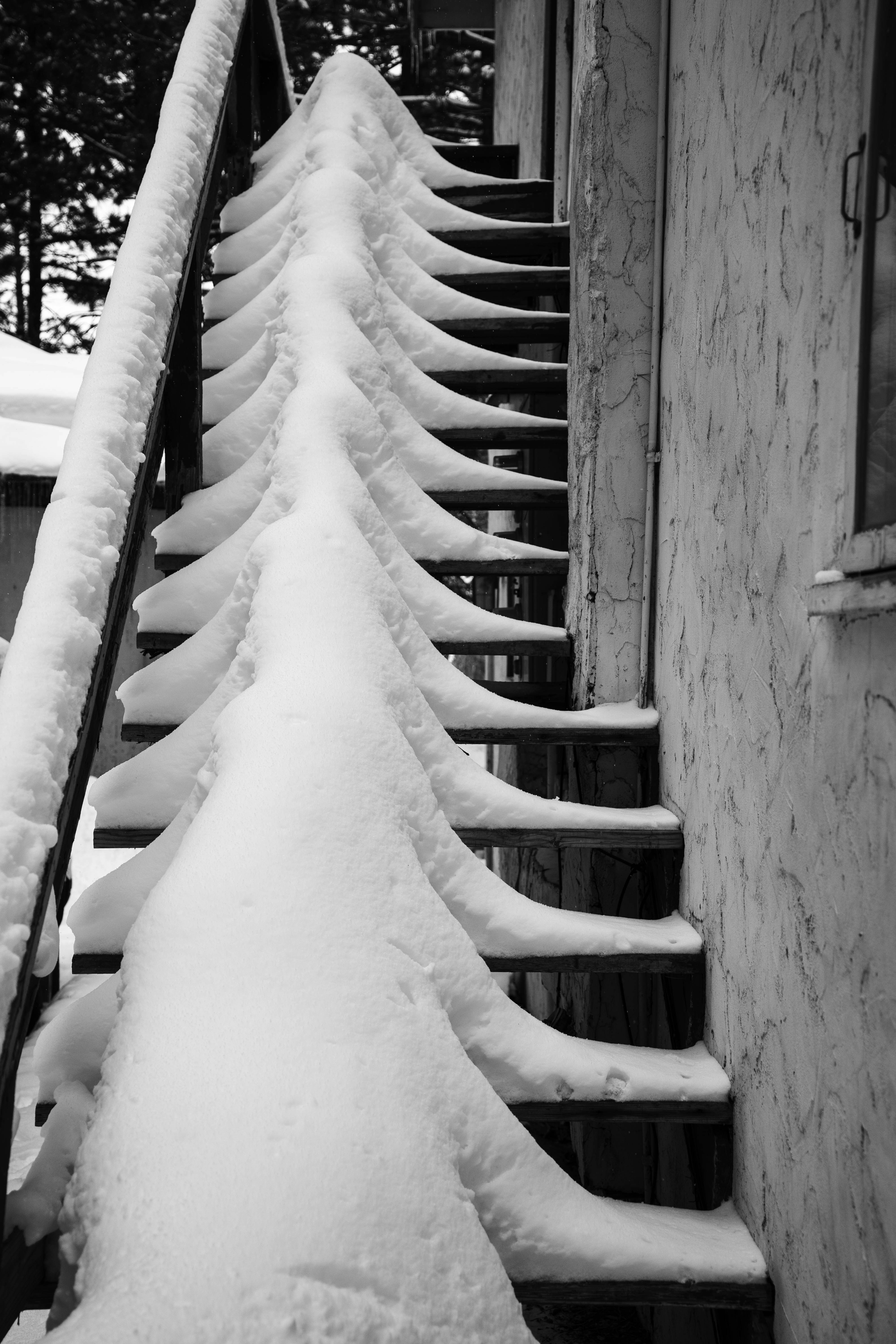 Snow-Trimmed Steps: Monochrome Rhythm Along a Weathered Exterior Staircase