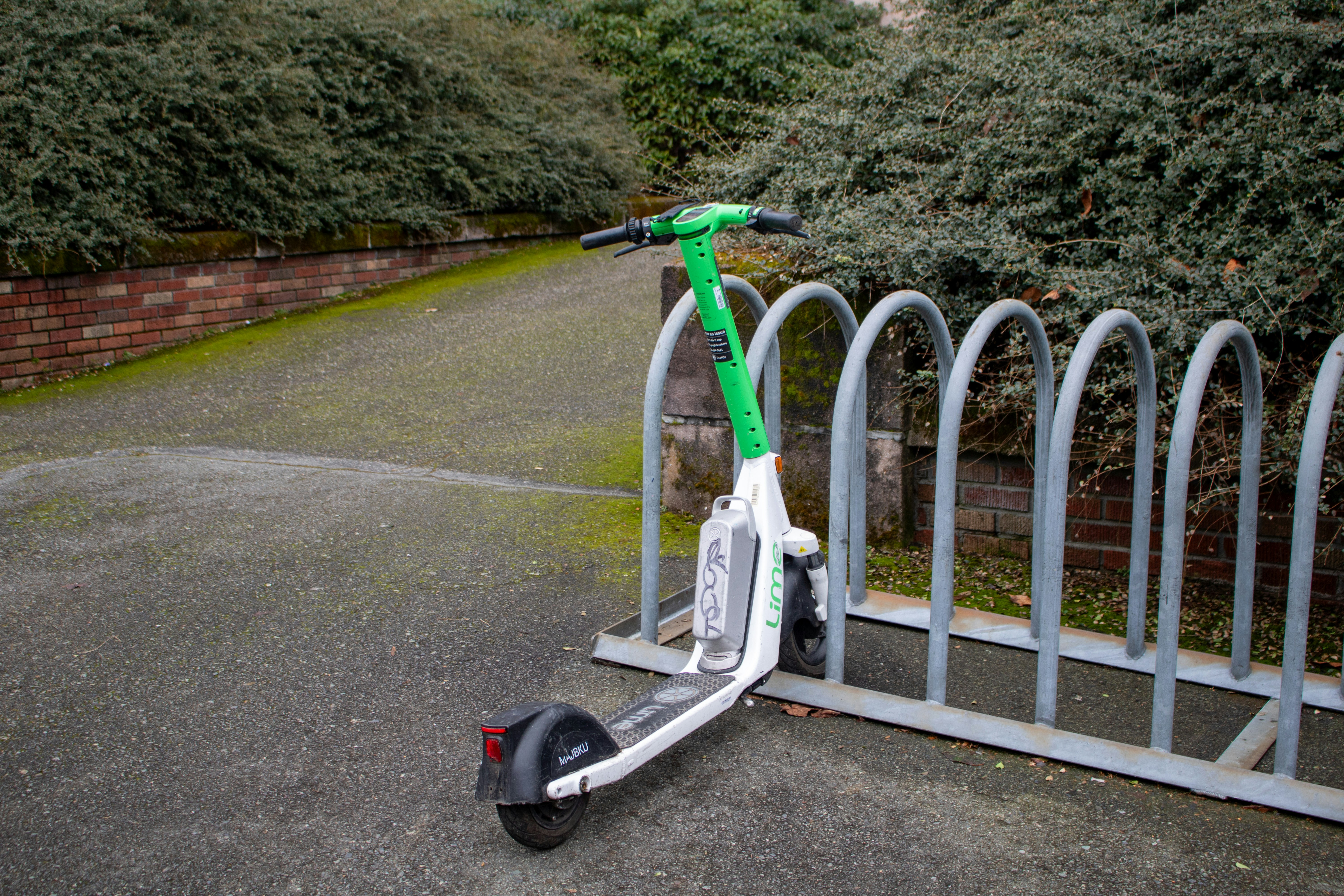 A lime scooter is parked in a rack. photo – Free City Image on Unsplash