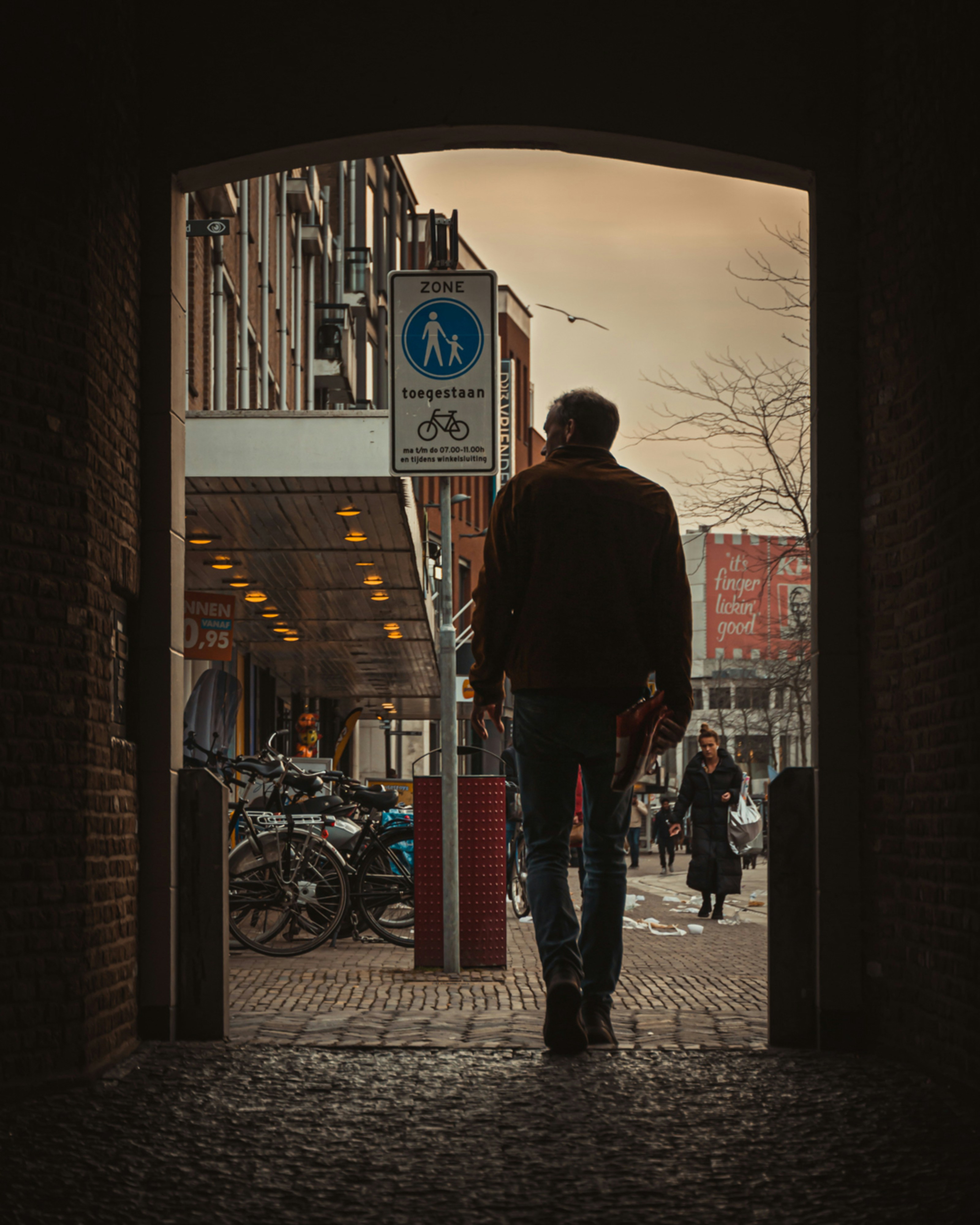 Amber Archway into the Evening Street: A Pedestrian Moves Toward the City