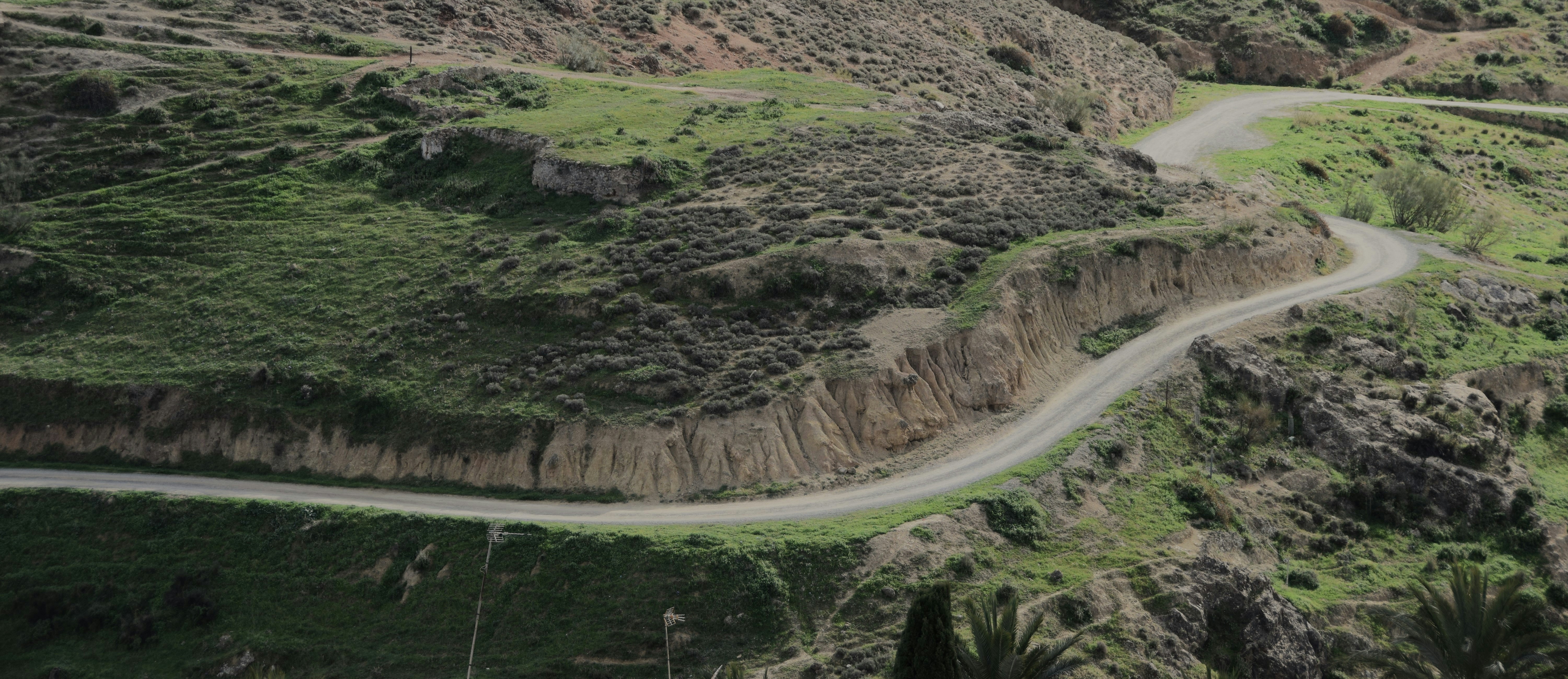 La carretera sinuosa sube a través de un terreno verde y montañoso ...