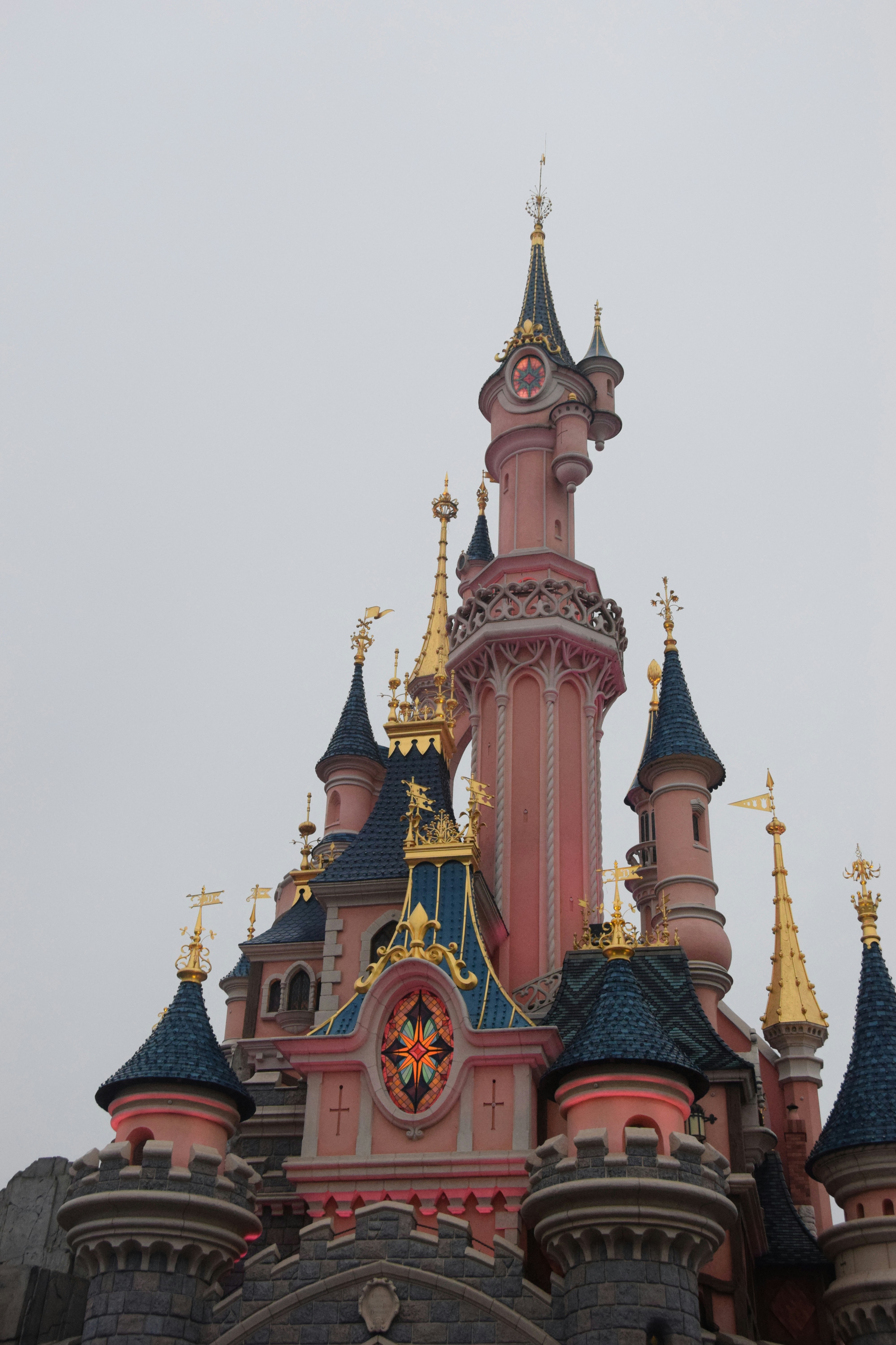 Pink-Coral Citadel: Azure Turrets and Golden Spires Under an Overcast Sky