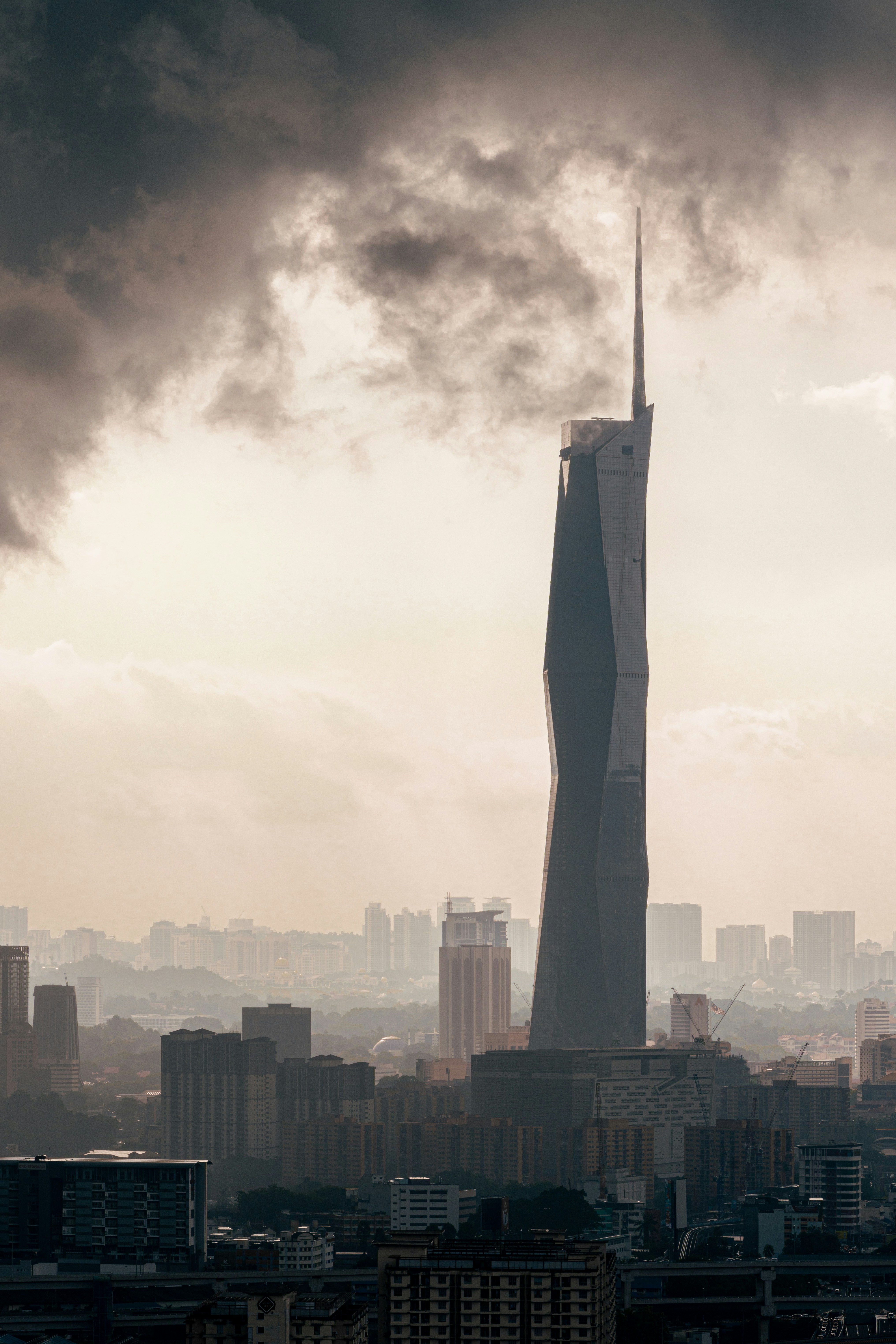 A modern skyscraper stands tall under ominous clouds. photo – Free ...