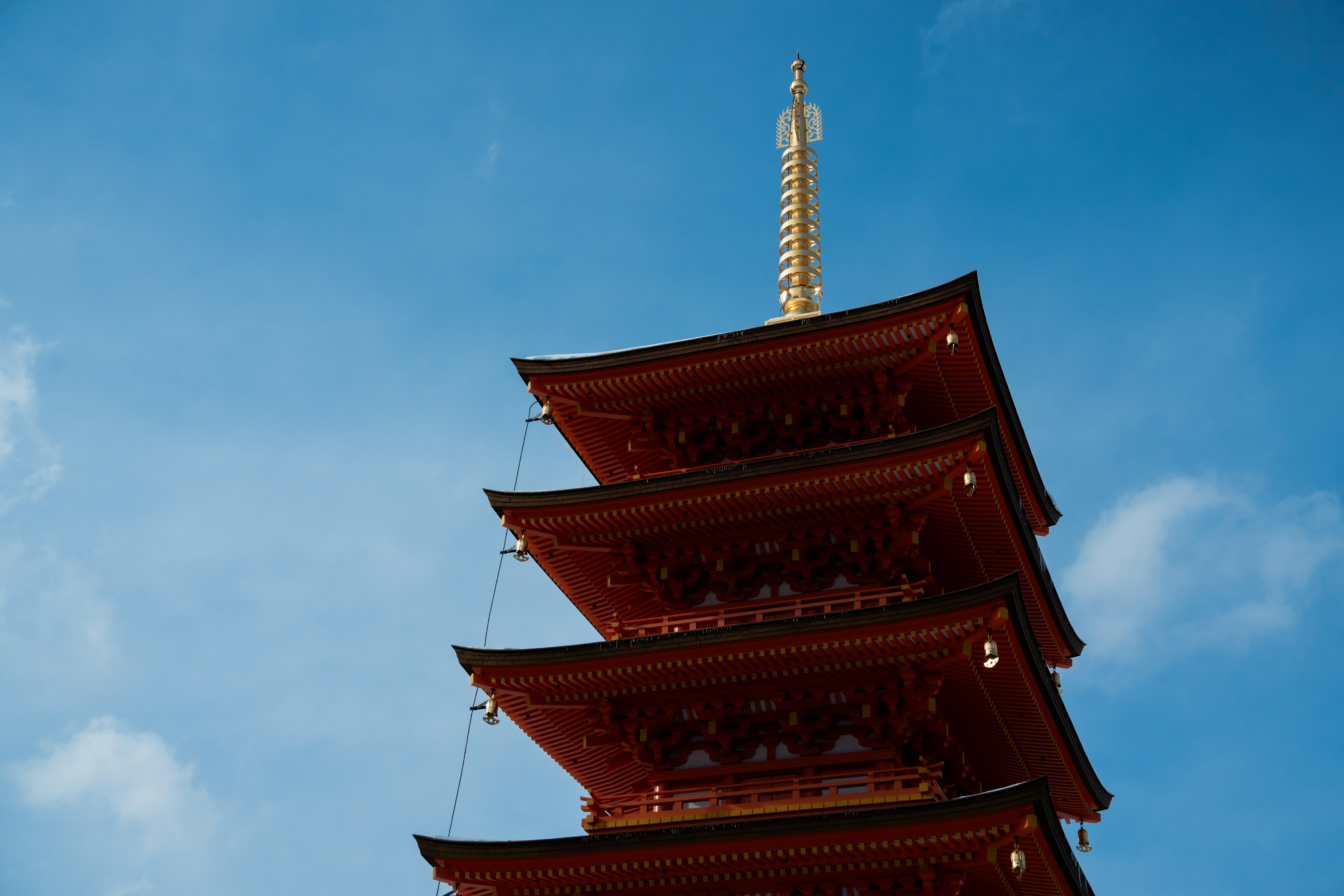 Japanese pagoda with intricate tiers silhouetted against a clear blue sky.
