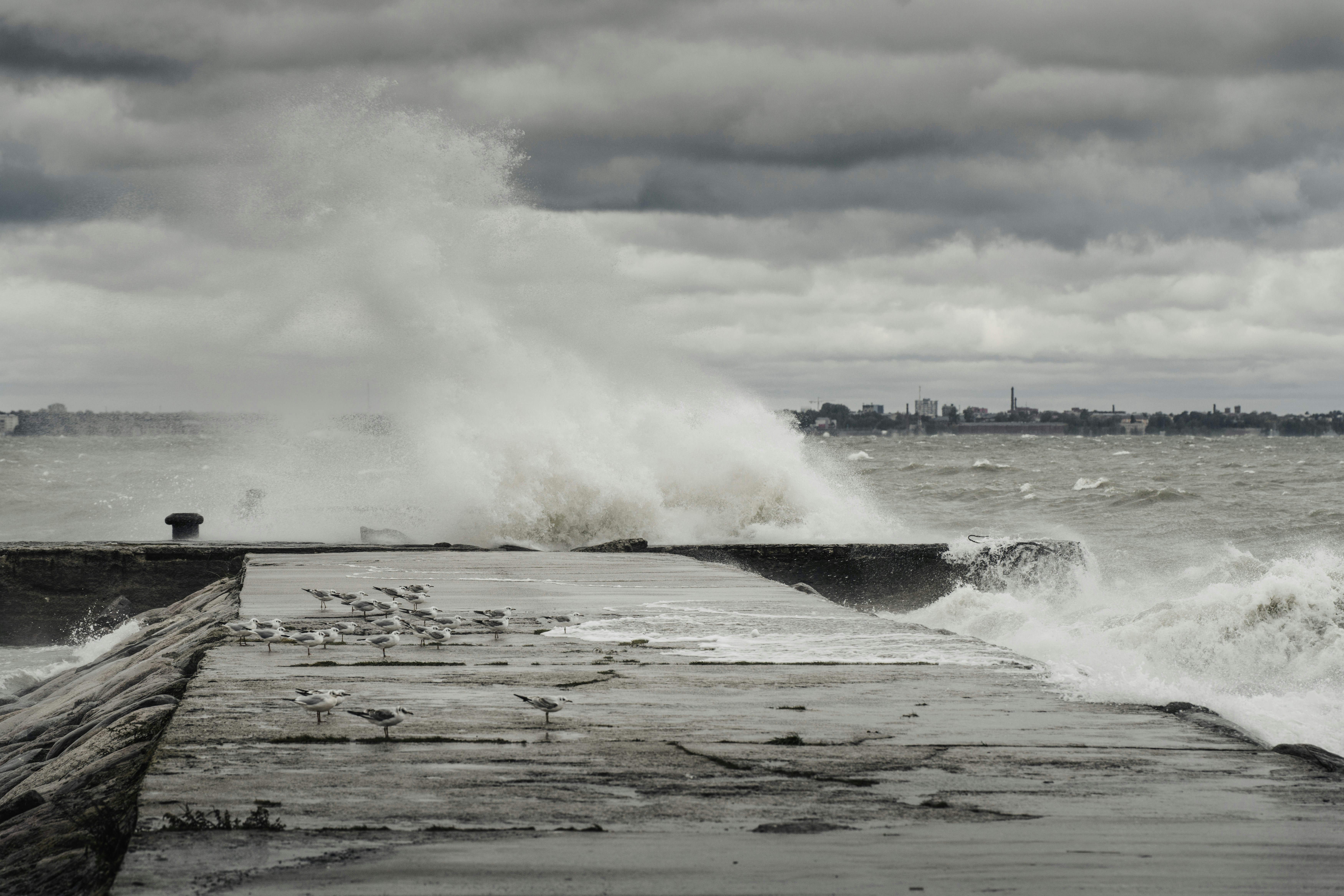 Waves crash over a concrete pier. photo – Free Sea Image on Unsplash