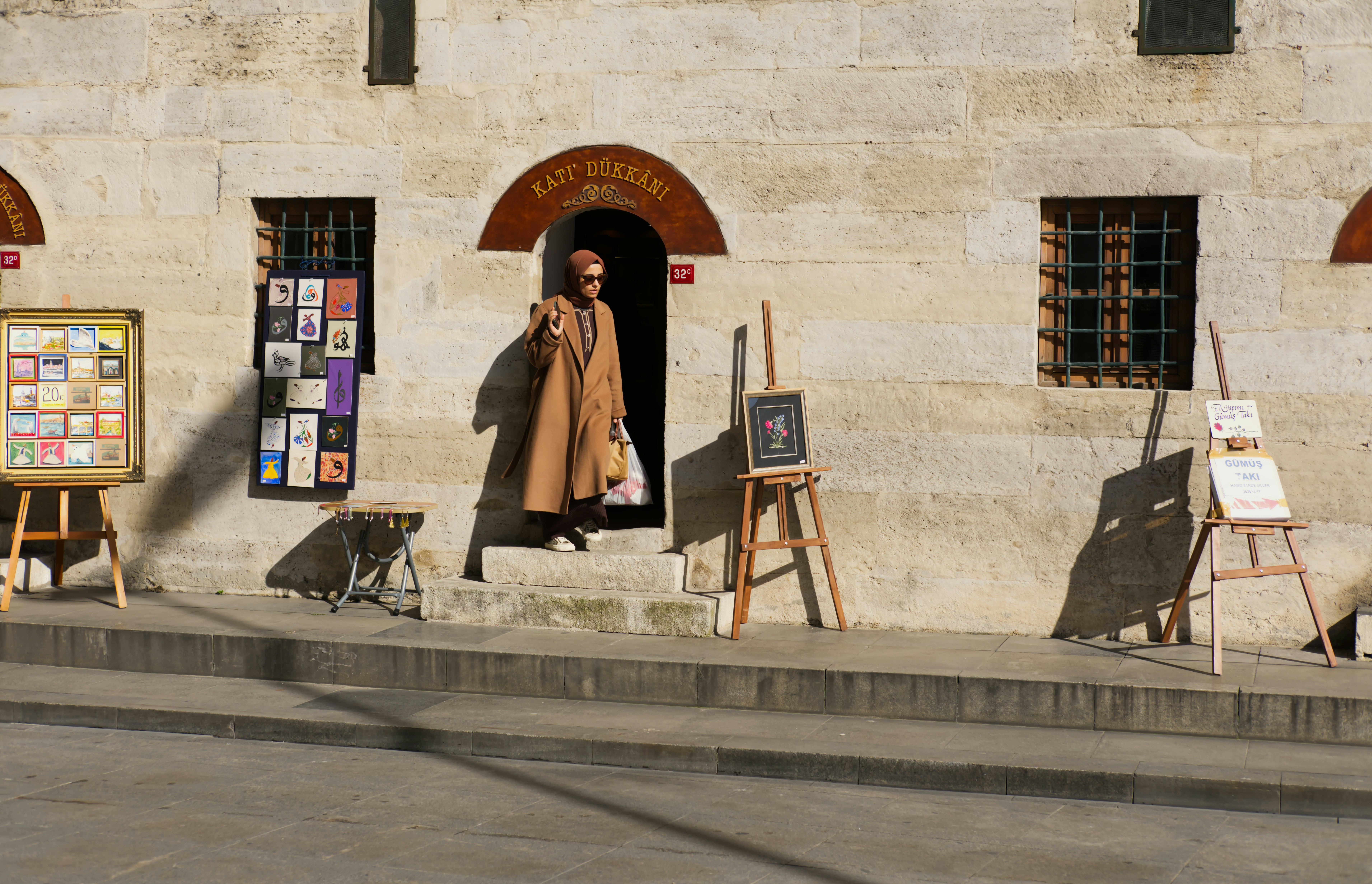 Woman stands in the doorway of a shop.