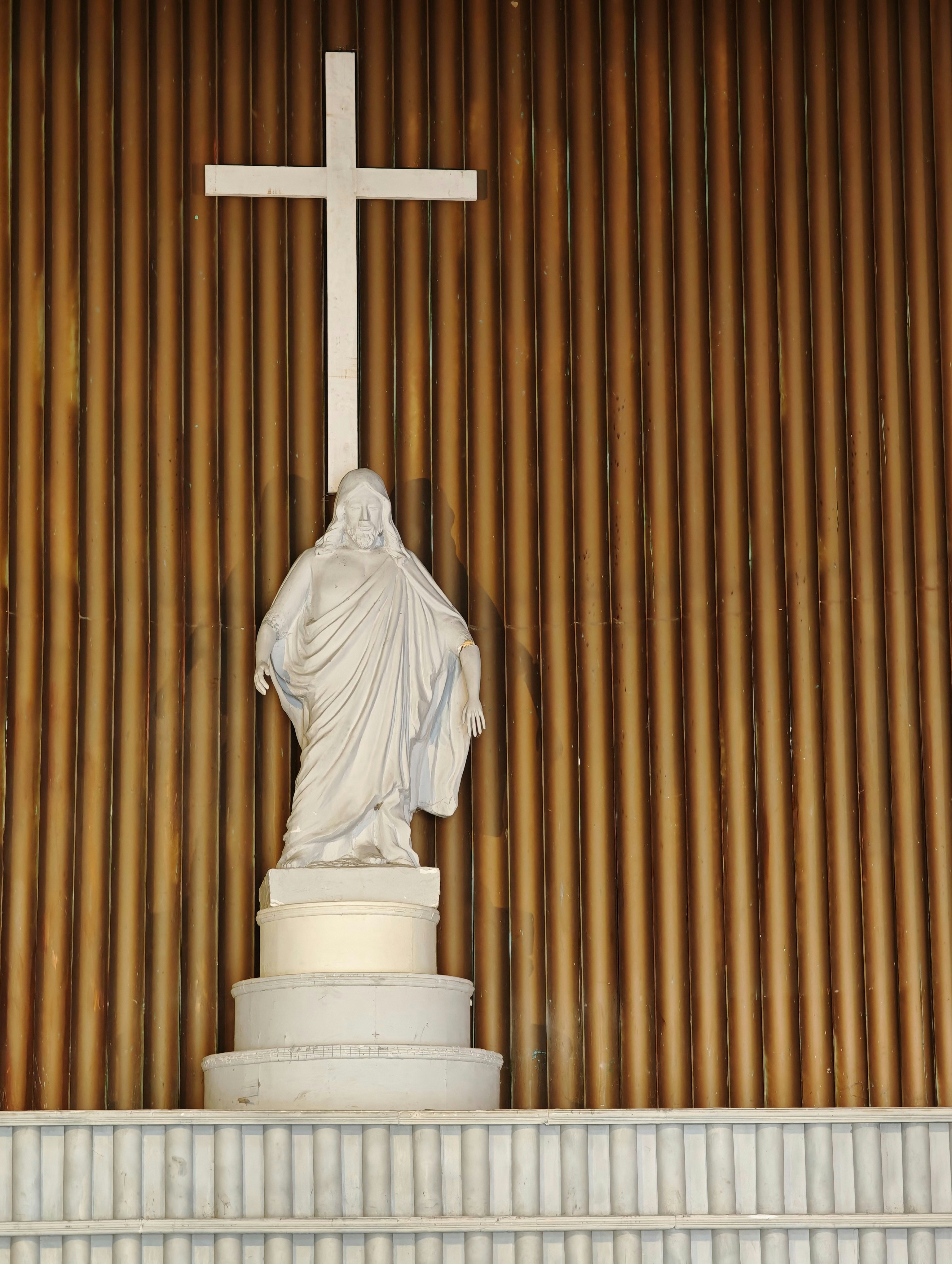 Jesus statue stands beneath a cross. photo – Free Woman Image on Unsplash