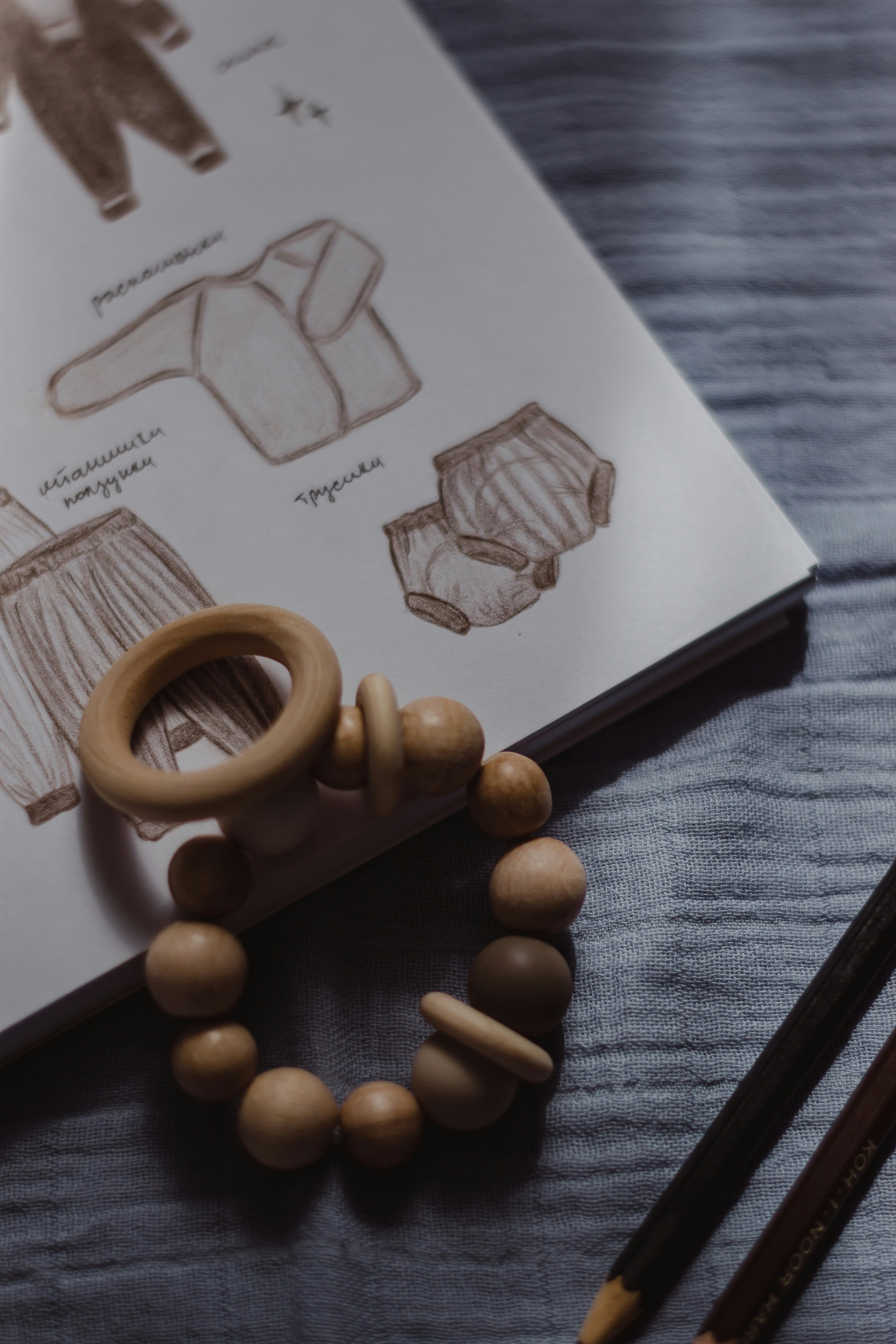Baby clothes designs with a wooden rattle.