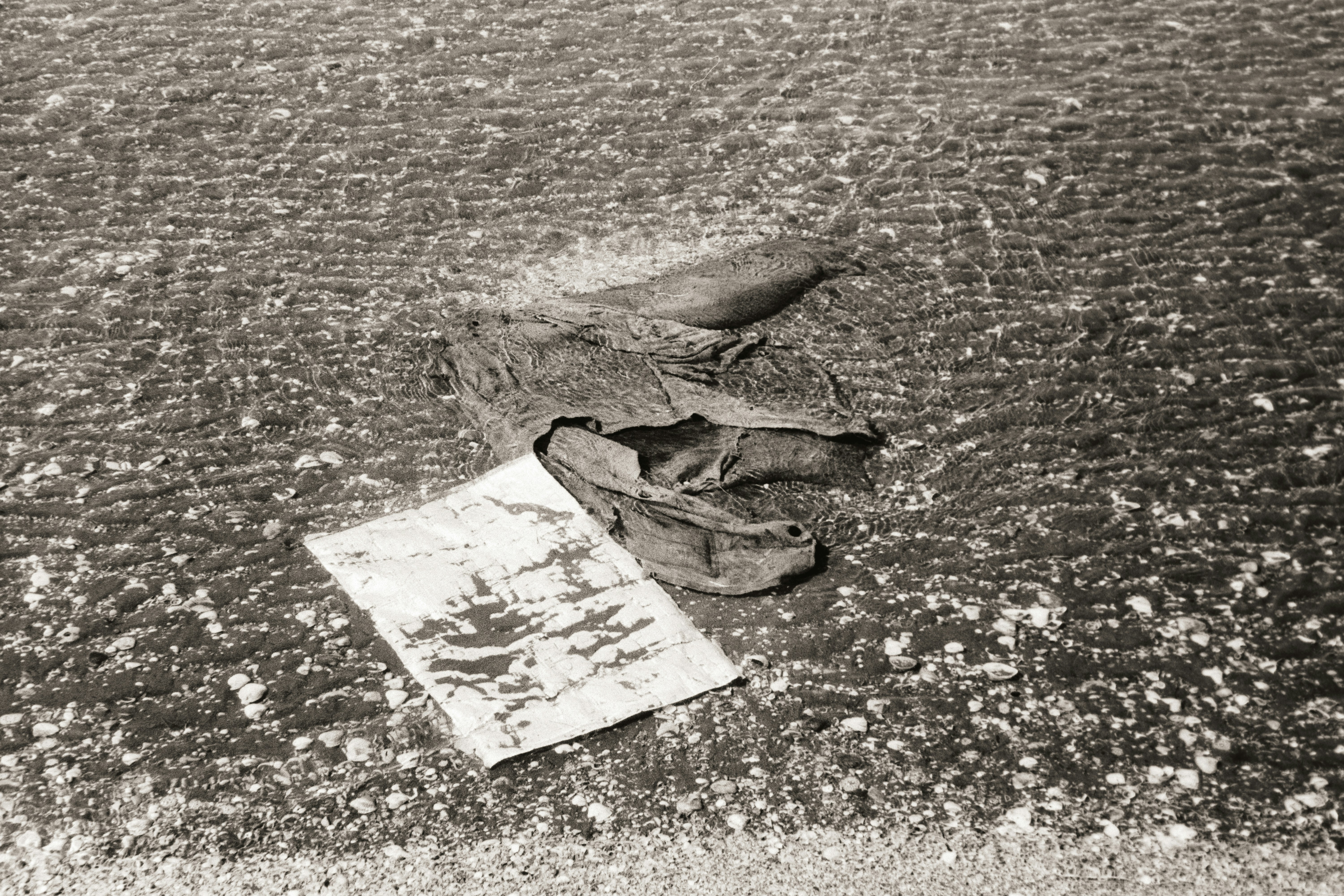 Paper and cloth rest on textured pavement. photo – Free Art Image on ...