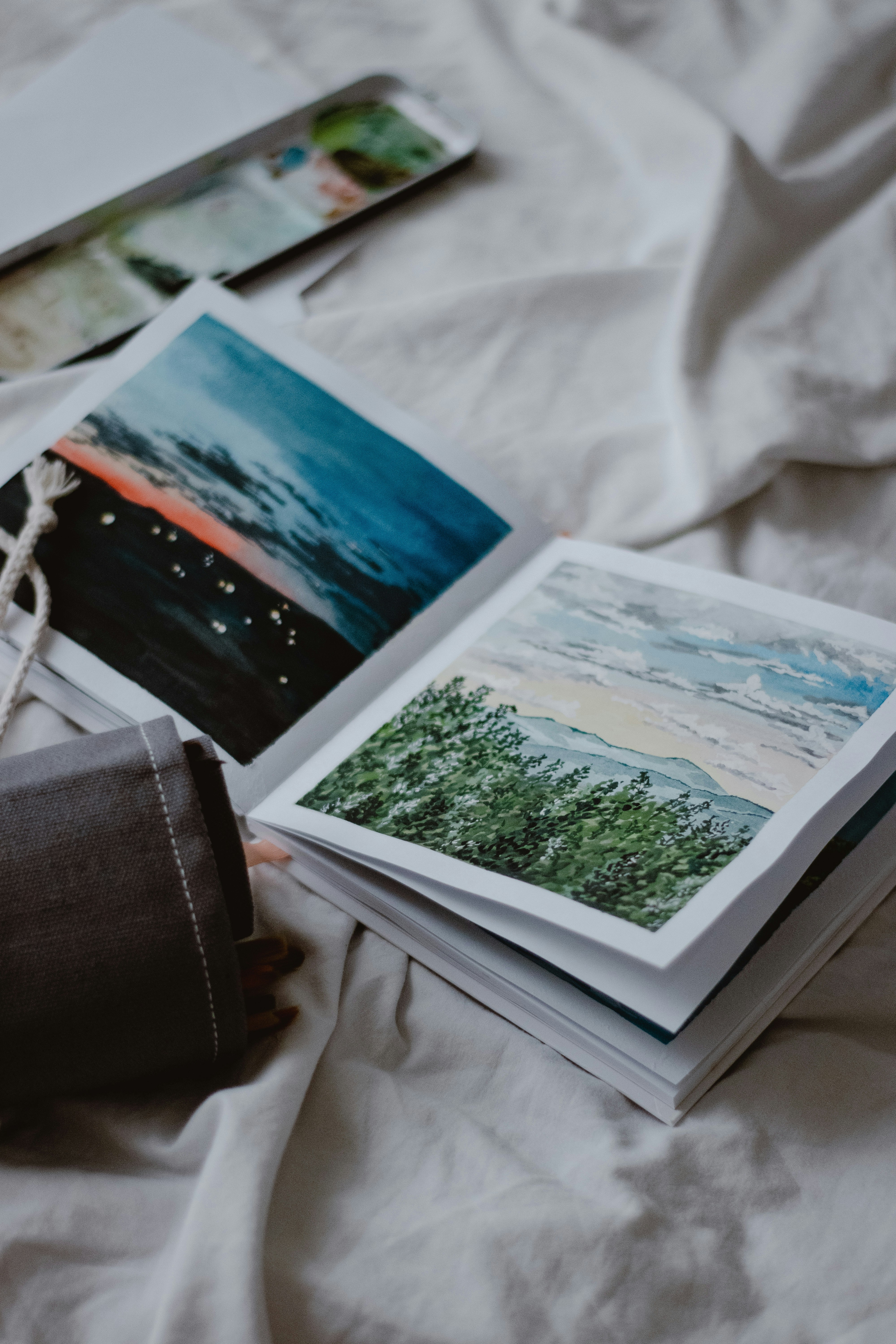 Watercolor paintings and art supplies on a bed. photo – Free Book Image ...