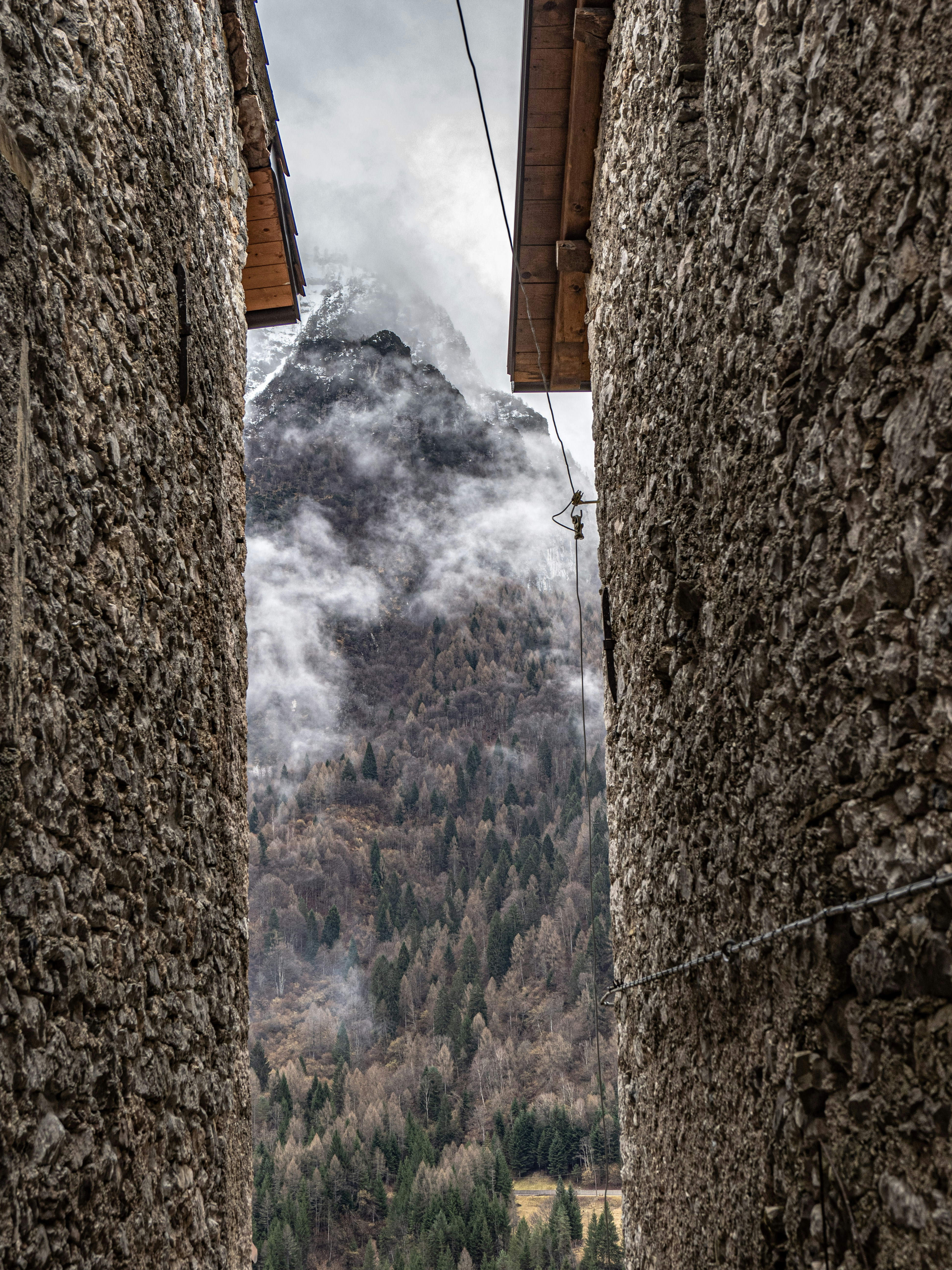 Framed Ascent: A Mist-Kissed Peak Between Stone Walls