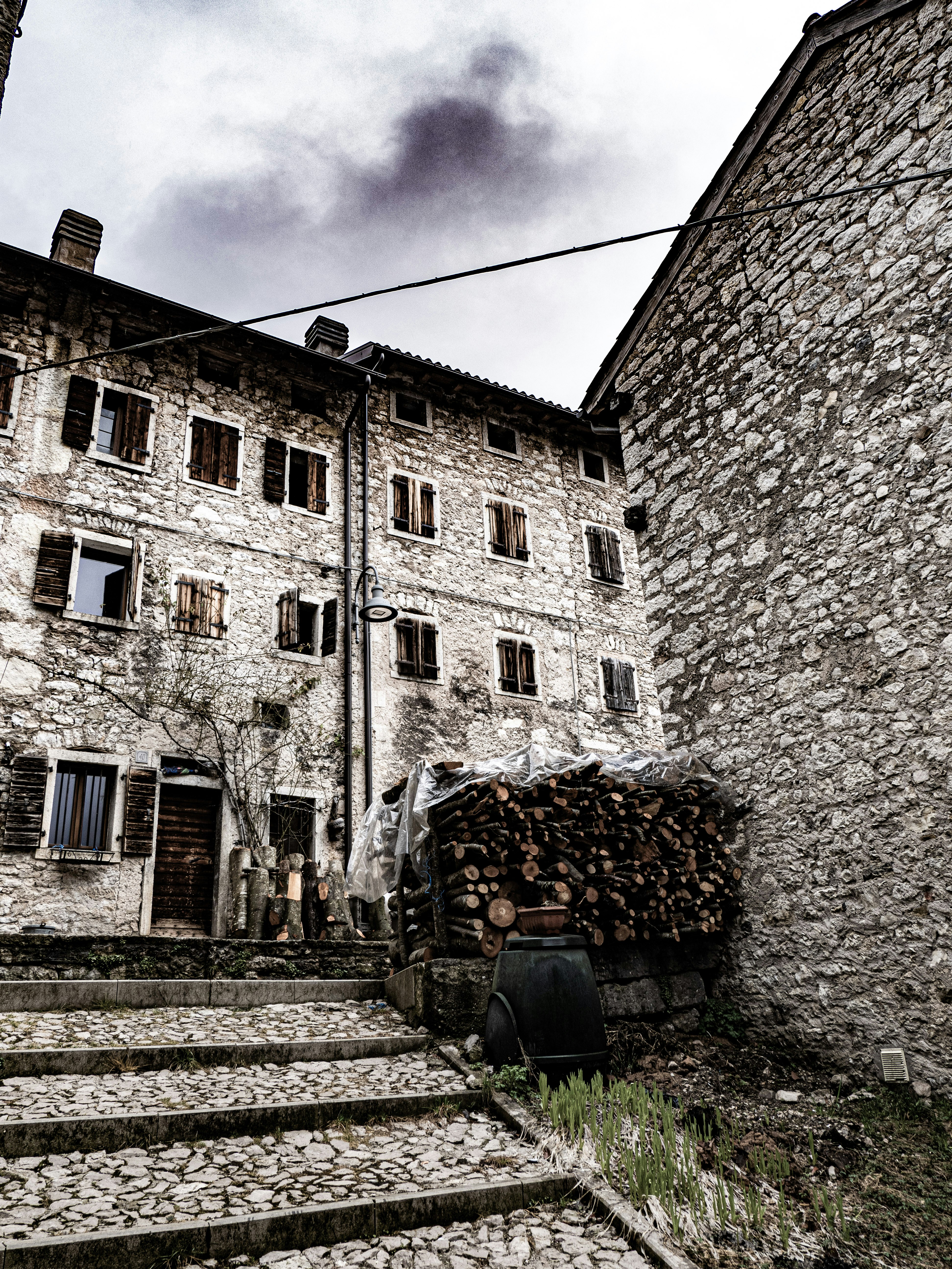 Staircase to a Log Stack in a Weathered Stone Courtyard