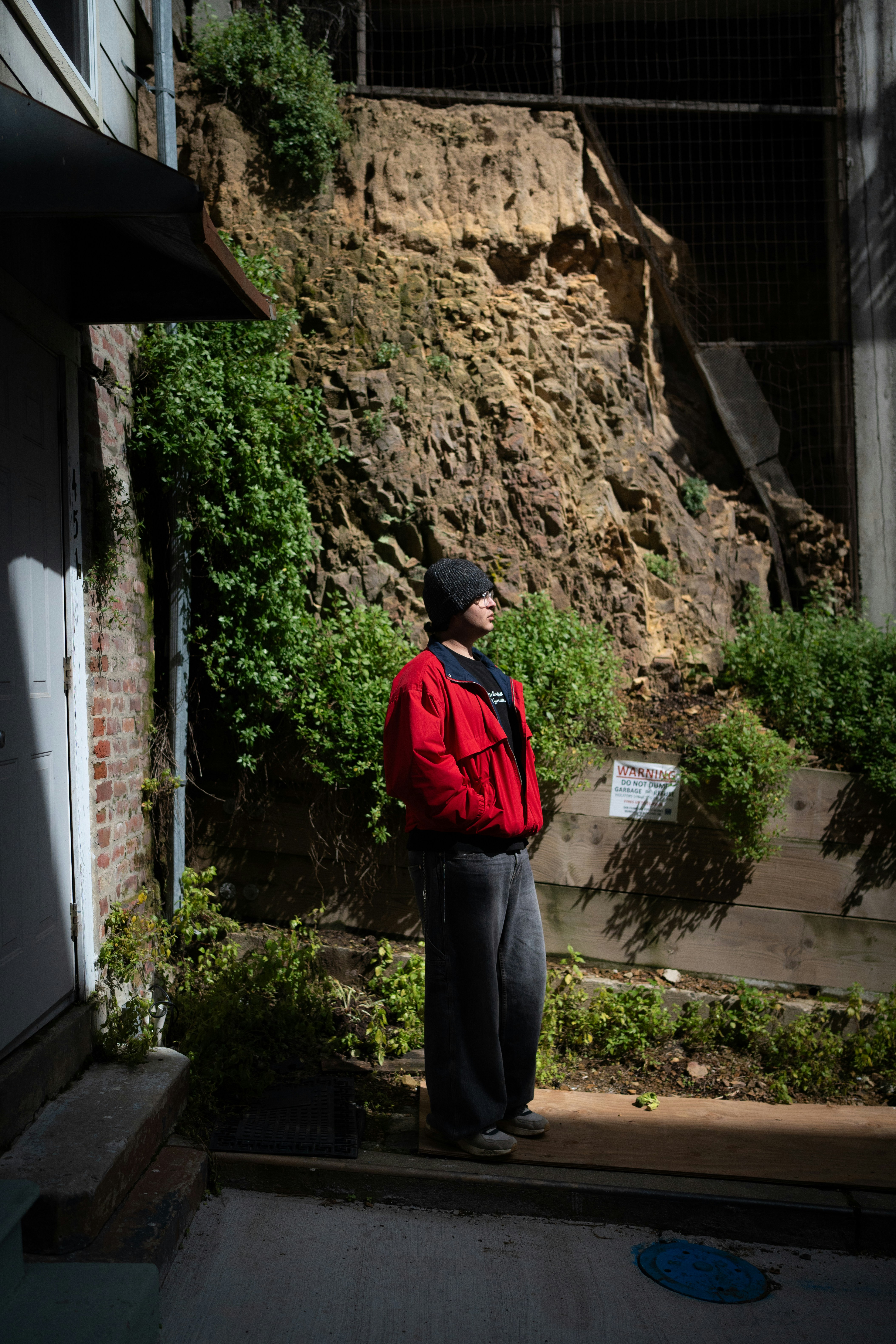 A person stands in front of a rugged cliff. photo – Free Portrait Image ...